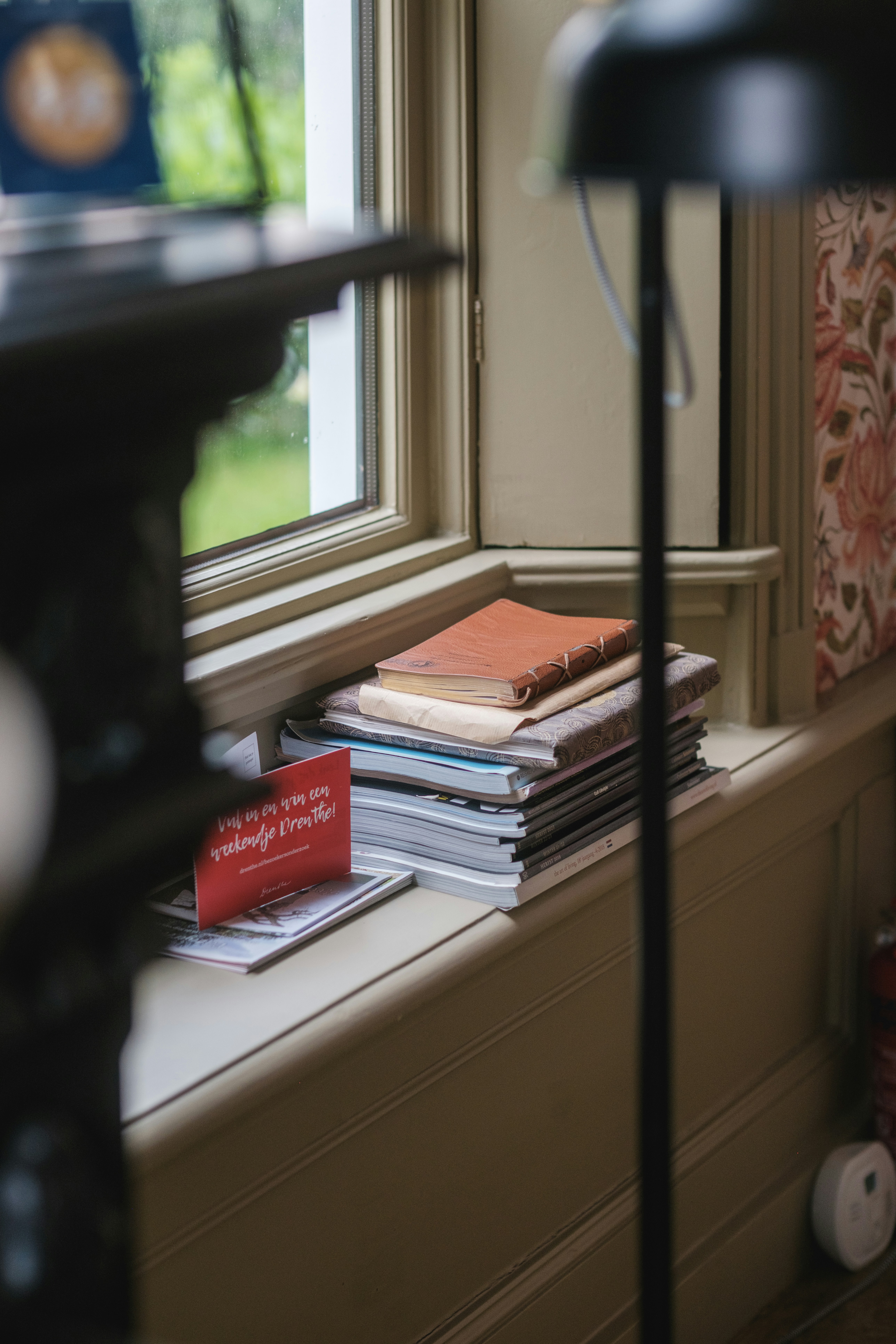 A stack of books sitting on top of a window sill photo – Free Lamp ...