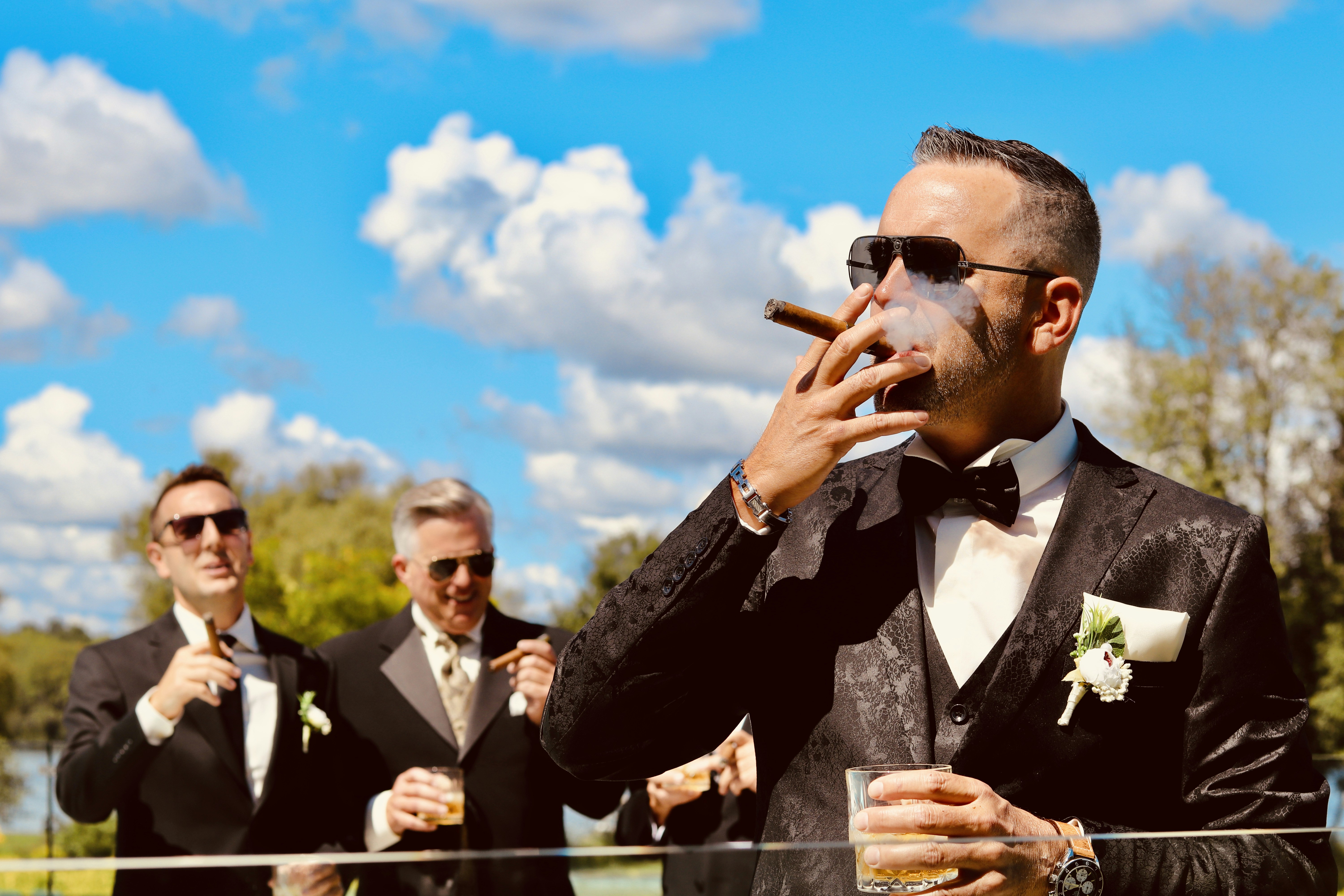 A man in a tuxedo smoking a cigarette photo – Free Man Image on Unsplash