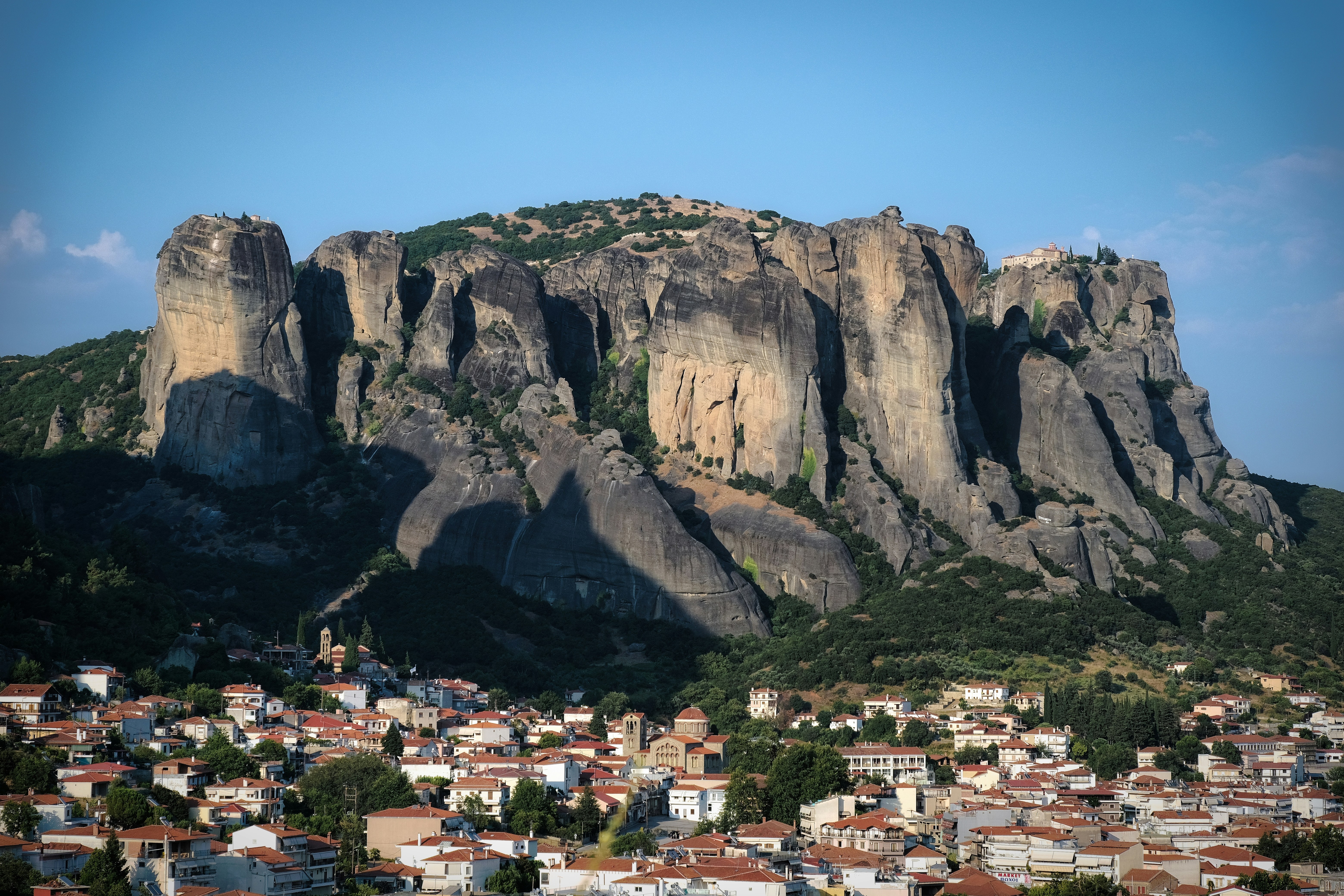 A large mountain with a city below it photo – Free Background Image on ...