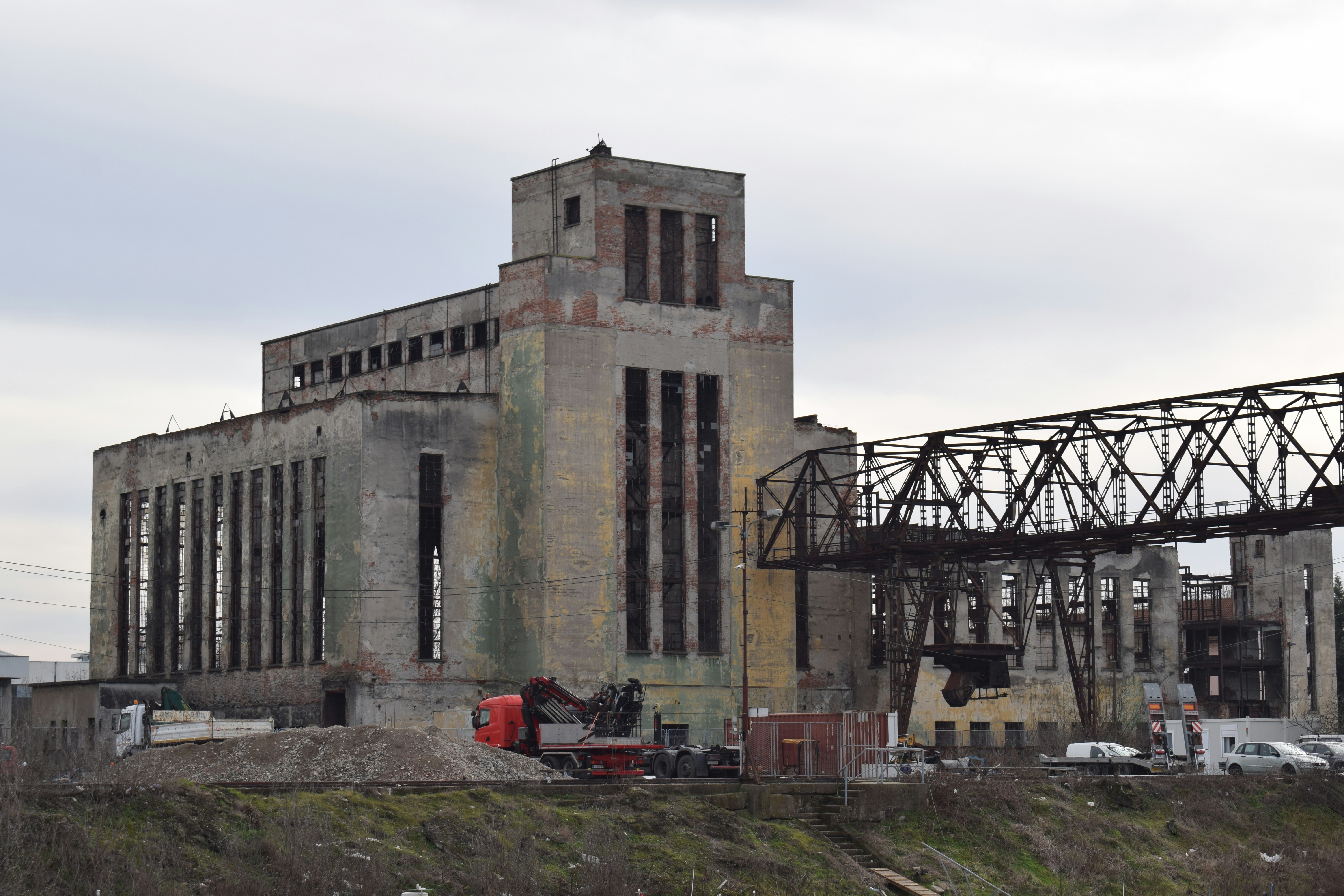 Concrete Behemoth and the Skeletal Crane under a Grey Skyline