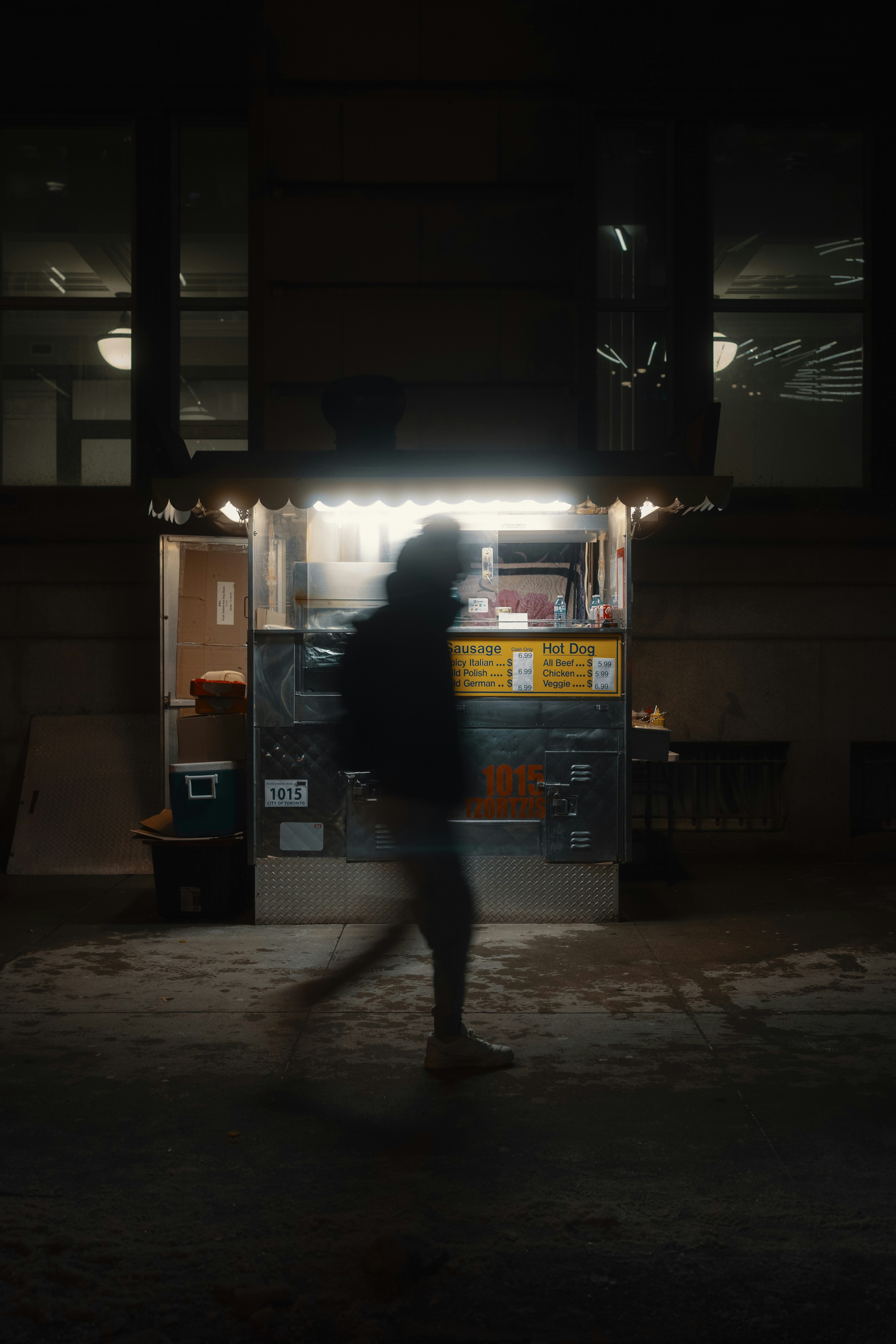 A man walking past a vending machine at night photo – Free Street ...