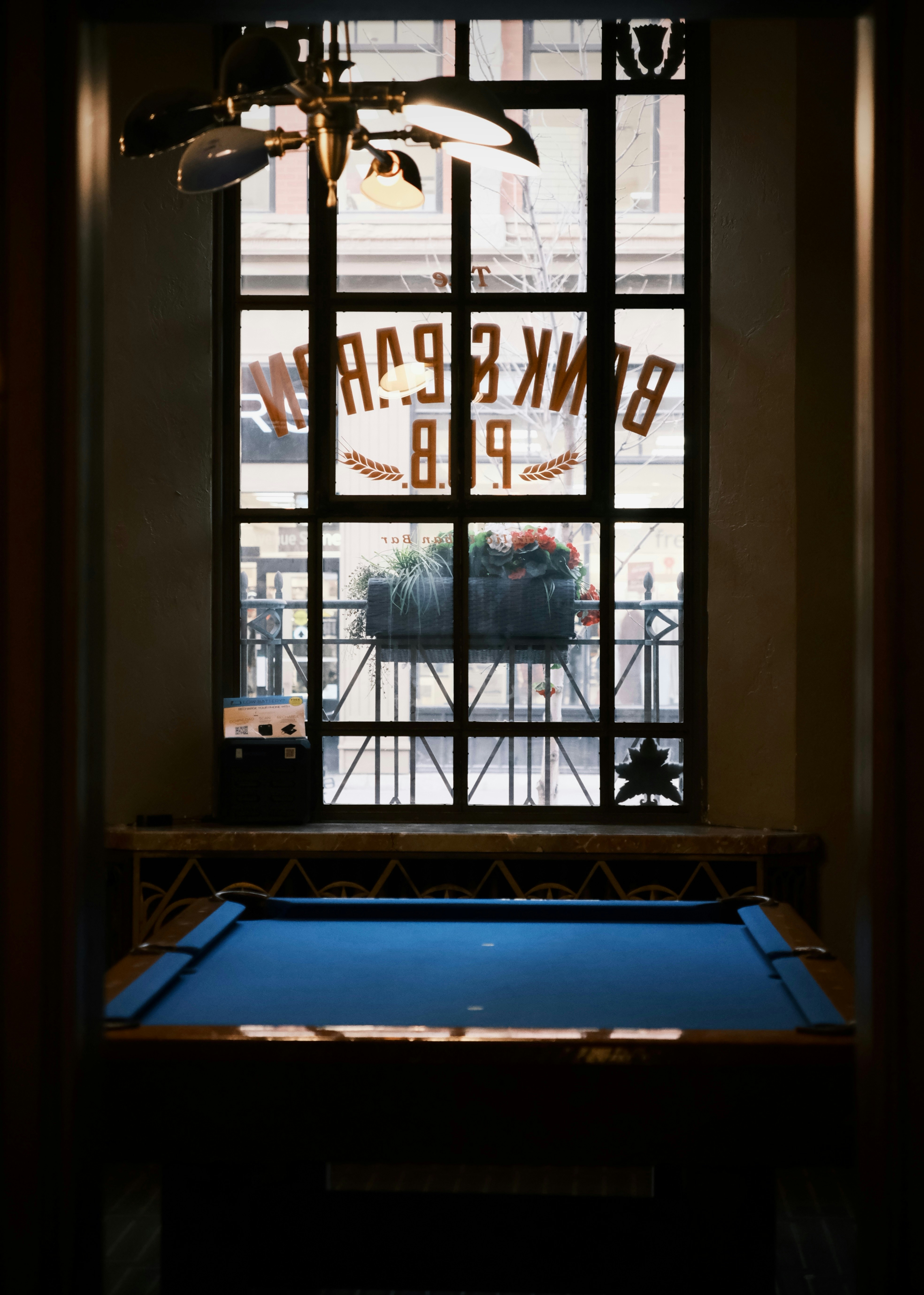Blue Billiard Table Beneath a Windowed City Light