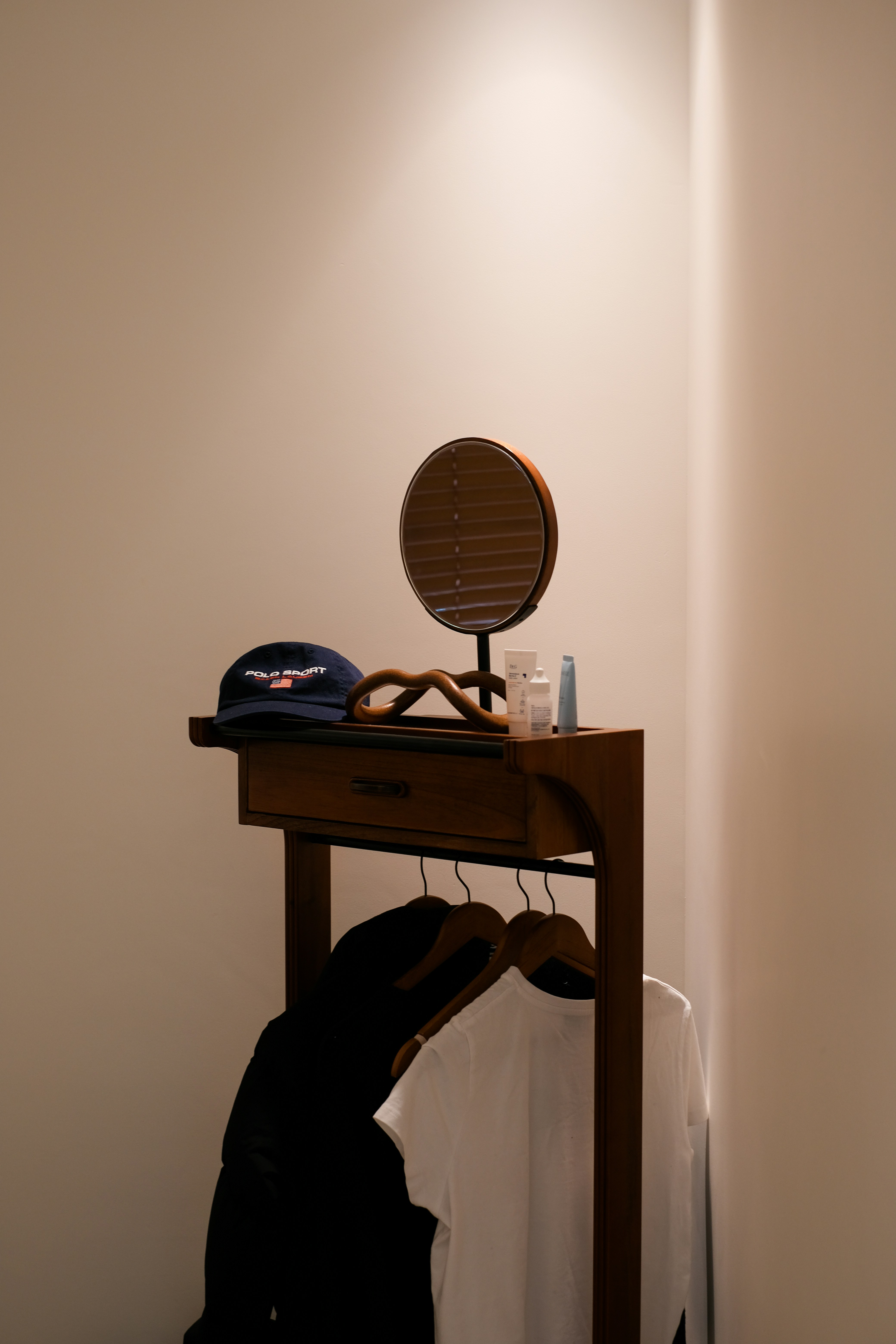 Round Mirror Nook: A Quiet Wardrobe Scene in Warm Indoor Light