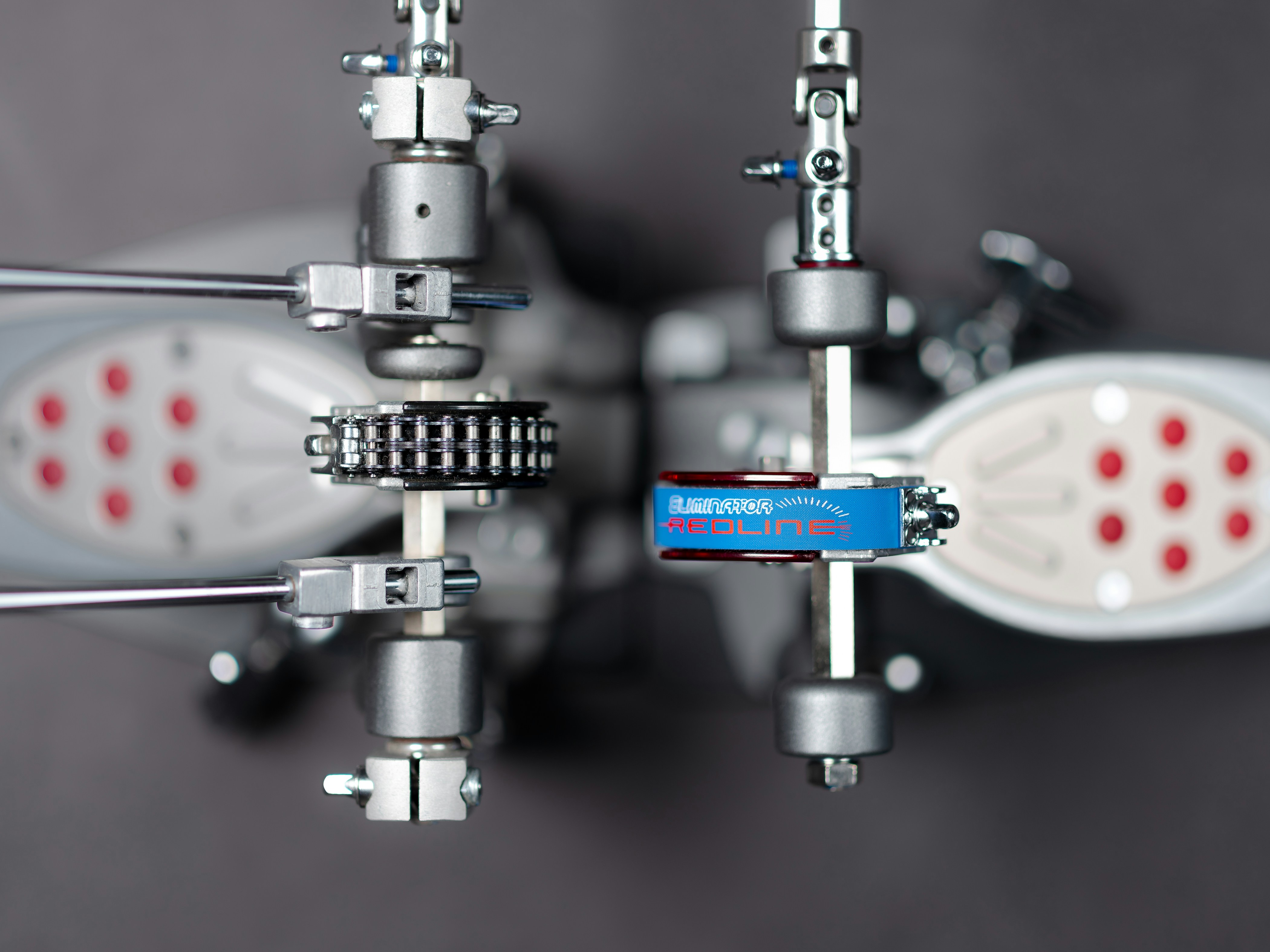 Close-up of twin drum pedals with intricate metalwork and chain mechanisms.