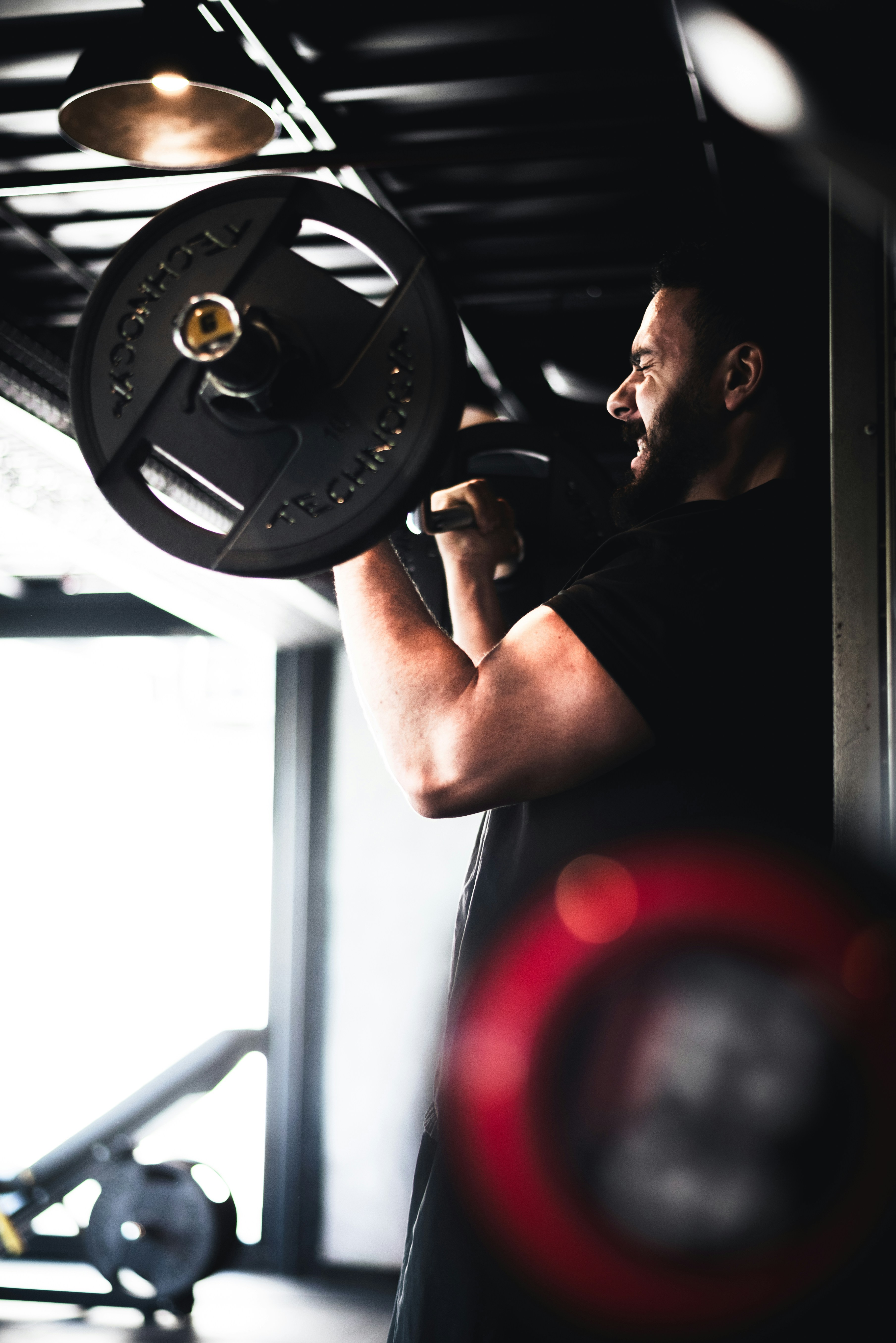 A man lifting a barbell in a gym photo – Free Man Image on Unsplash