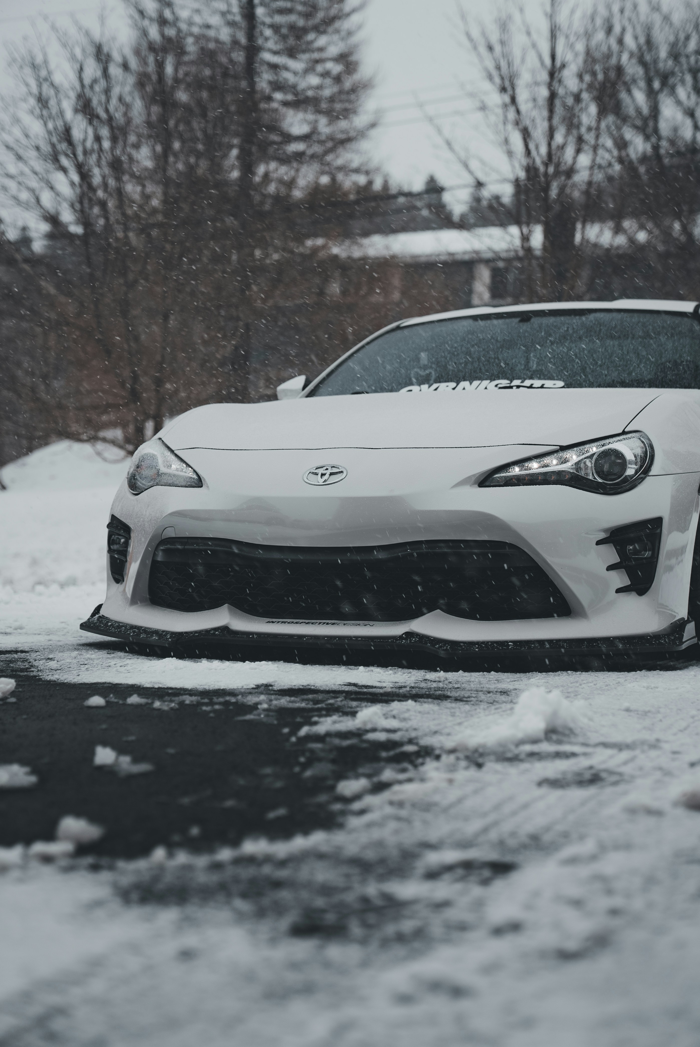 Snowbound Front Grille: A White Sports Coupe Anchored in Winter Silence