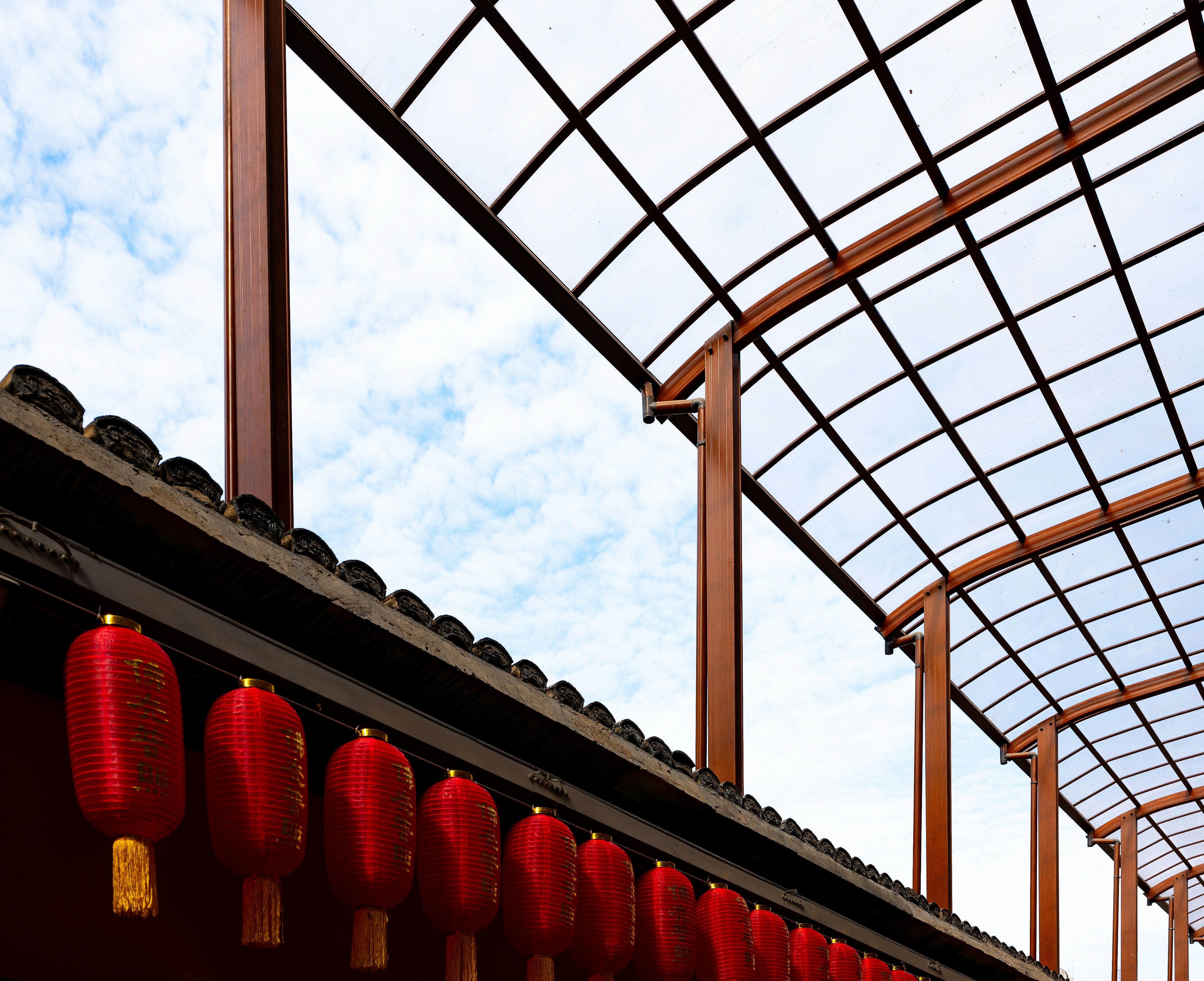 Crimson Lantern Row Framed by a Glass Canopy