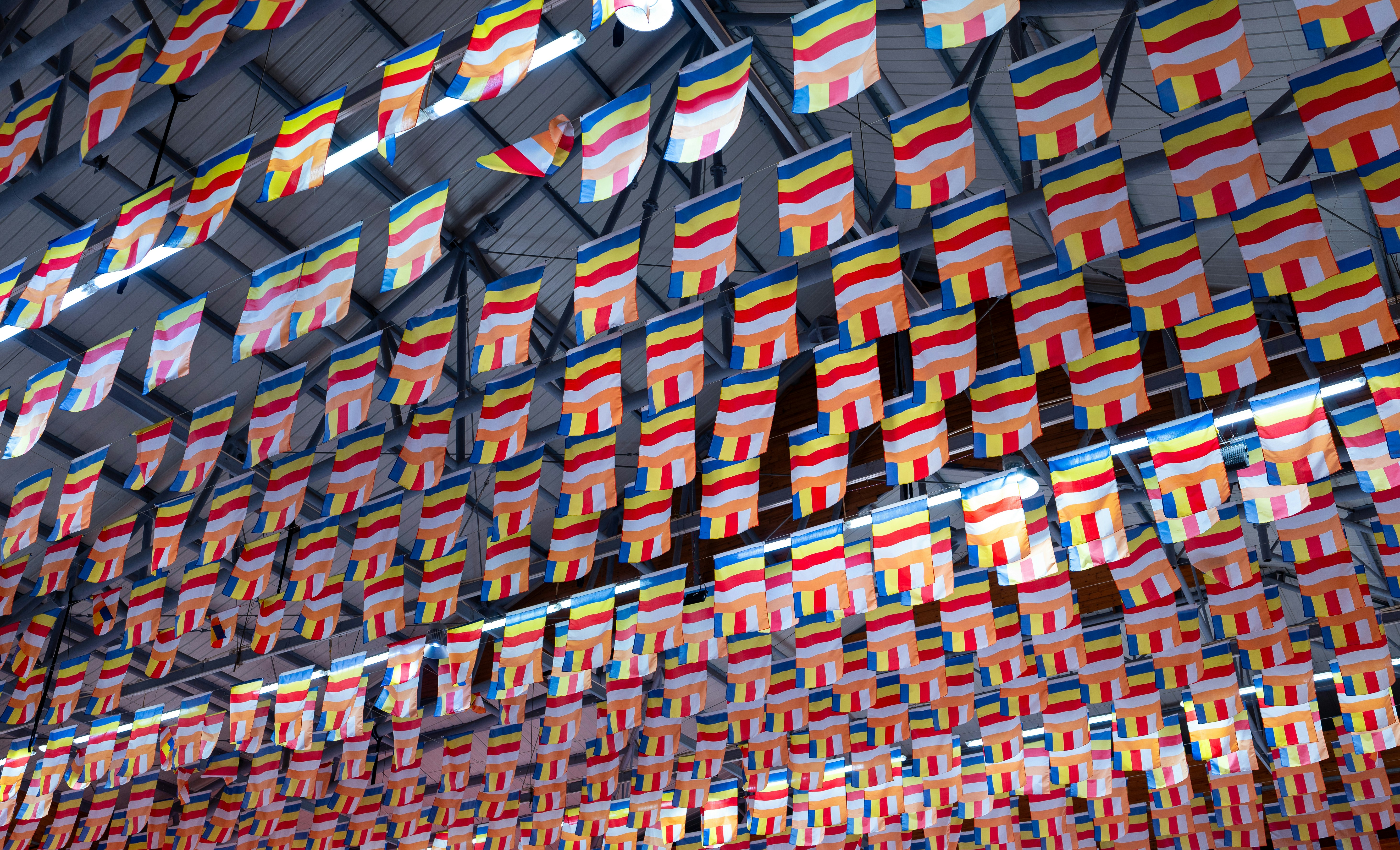 Kaleidoscope Canopy: Tibetan Prayer Flags Draped Across a Vaulted Interior