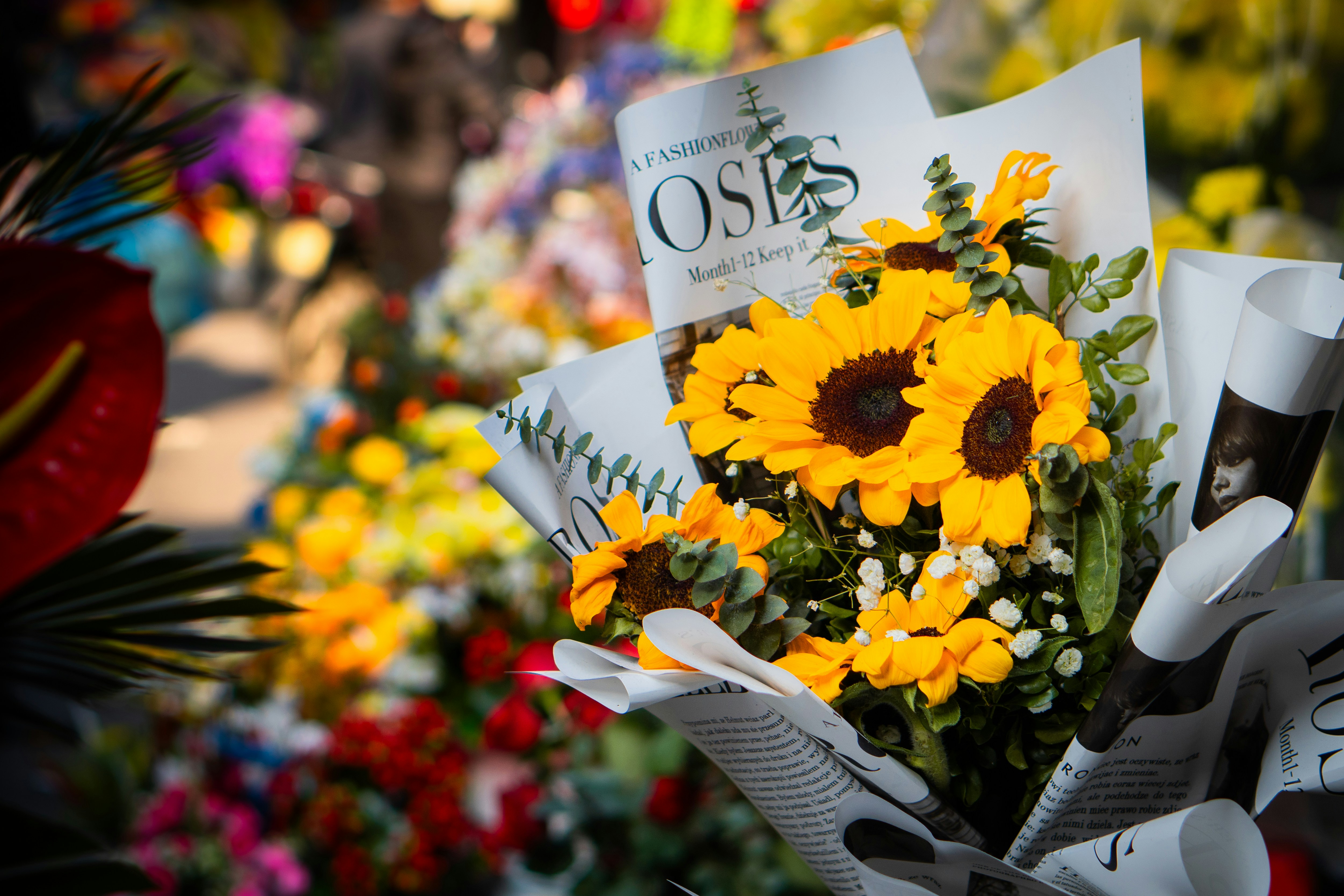 Sunflowers in Crinkled Newsprint: A Bold Bouquet Amid Market Color