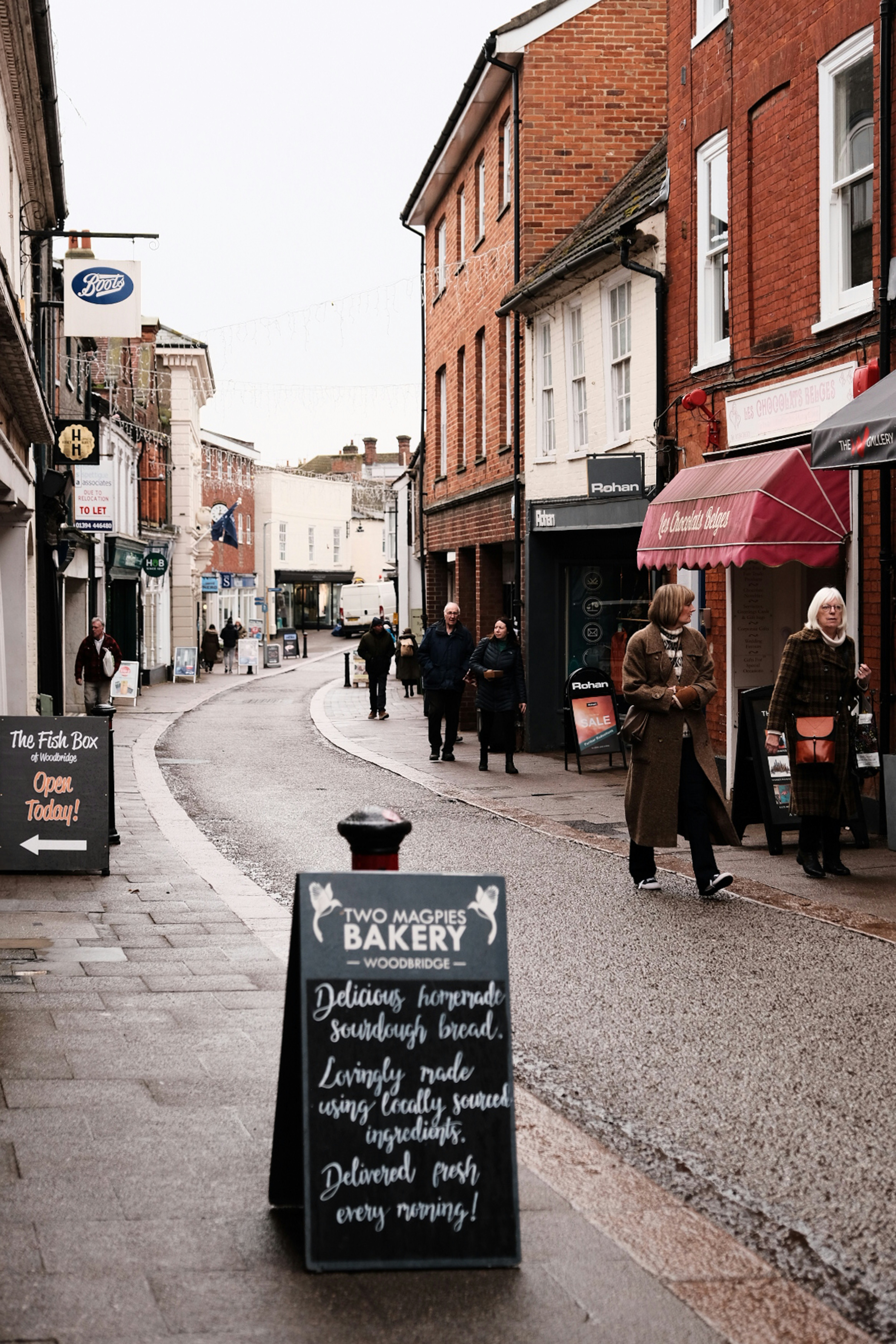 Chalkboard Sign Anchors a Brick-Walled Town Street