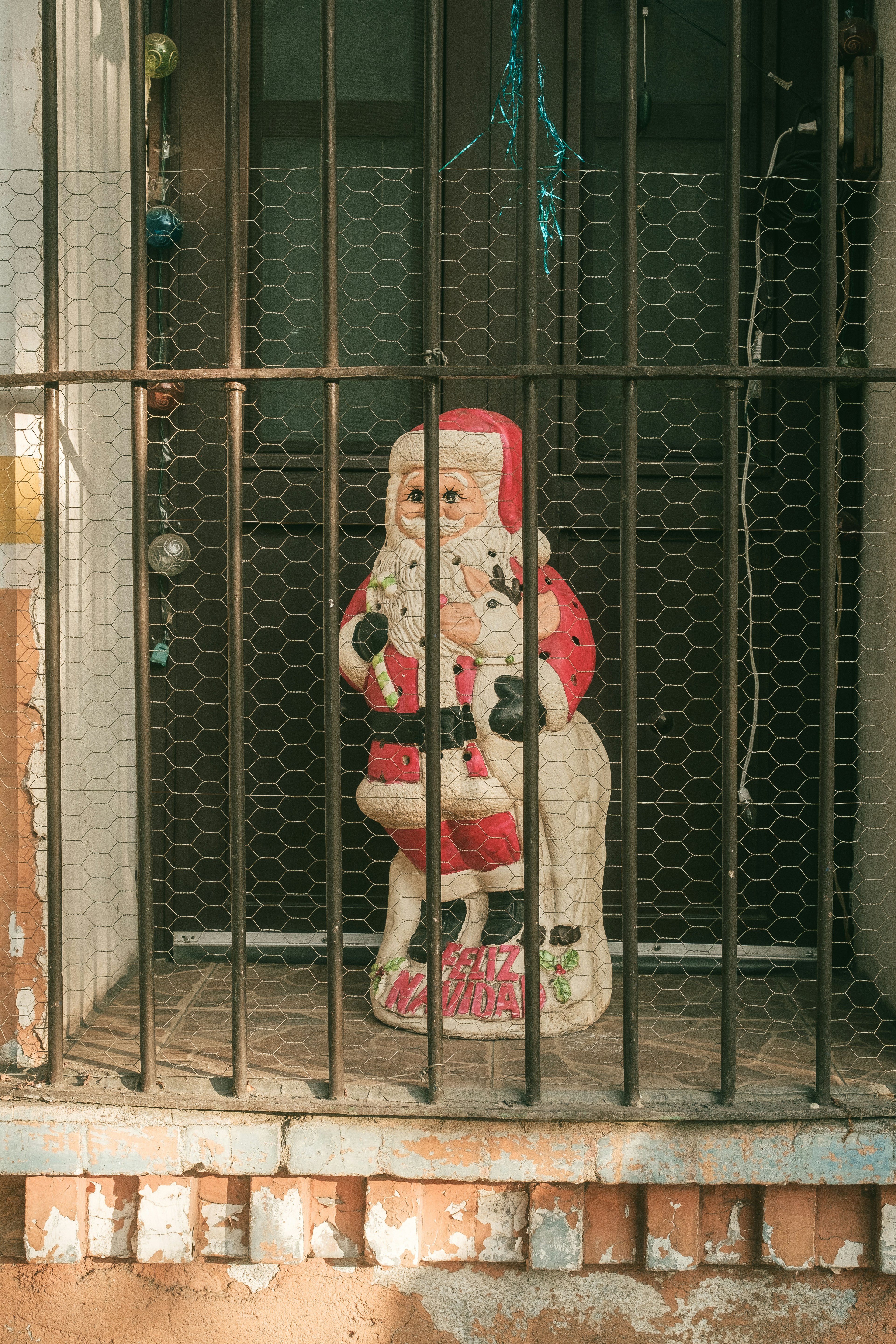 A statue of santa claus behind bars in a jail cell photo – Free Woman ...