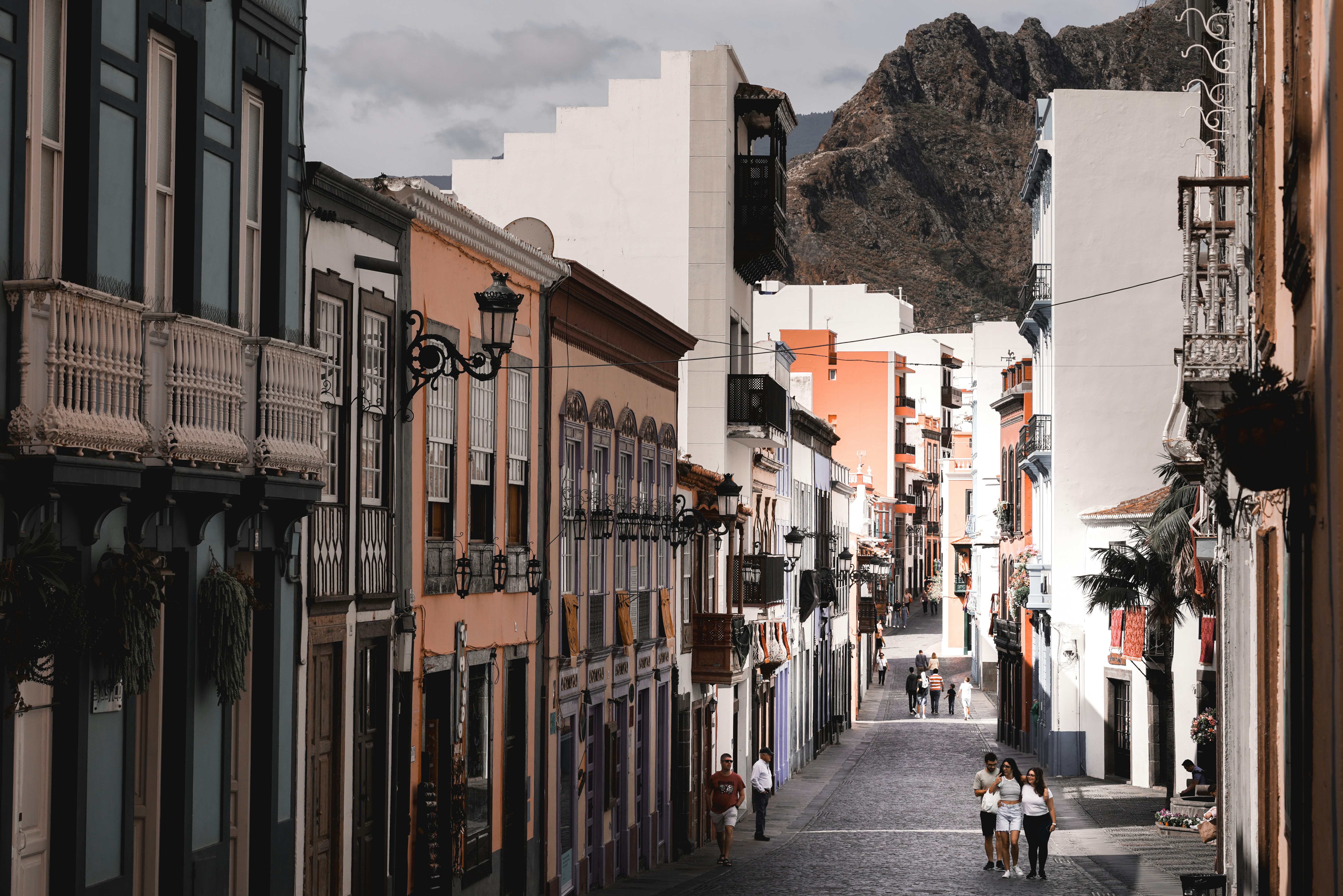 Scenic street with colorful historic buildings against rugged mountains.