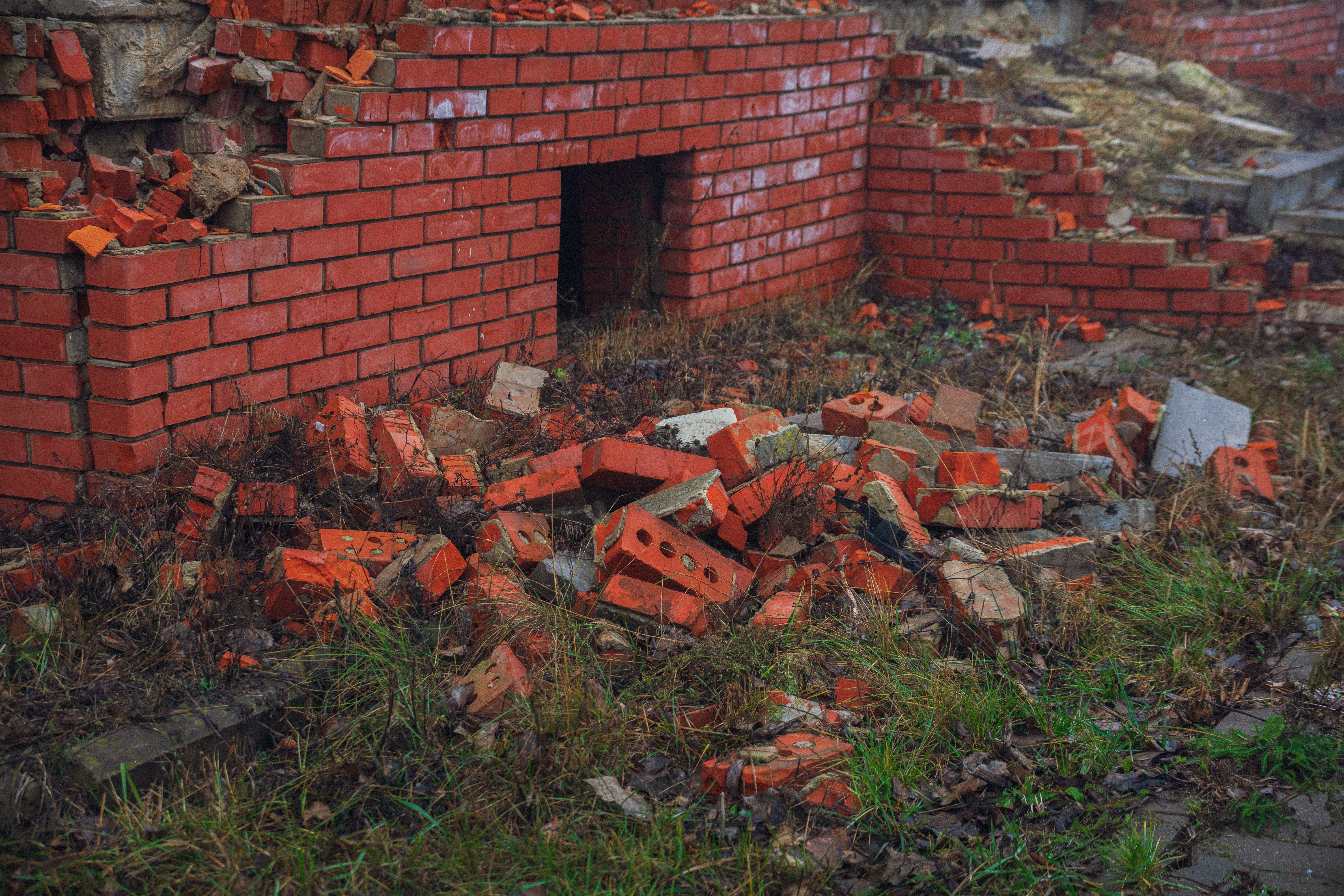 Weathered Doorway in Red Brick Ruins Amid Weedy Rubble