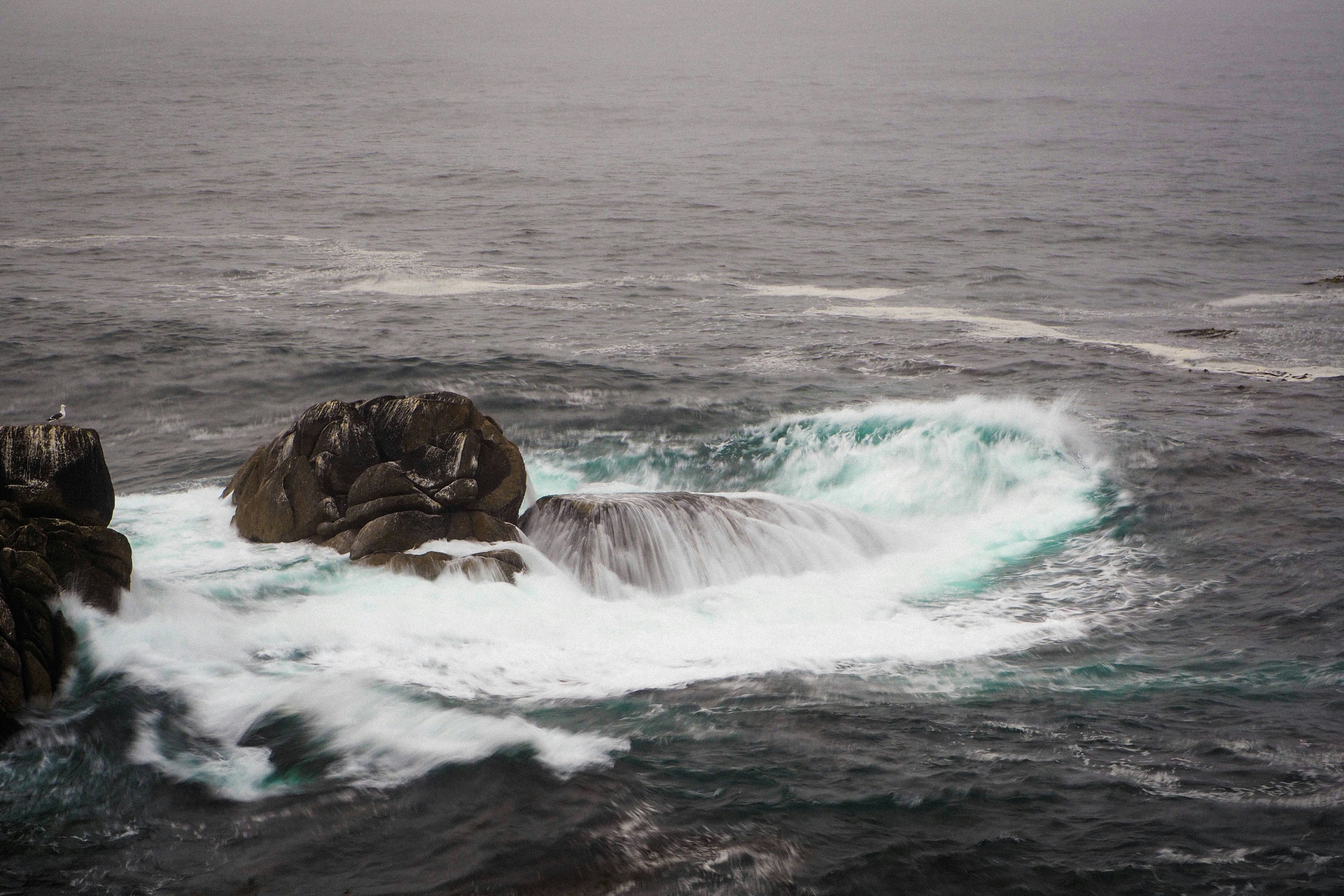 A large body of water surrounded by rocks photo – Free California Image ...