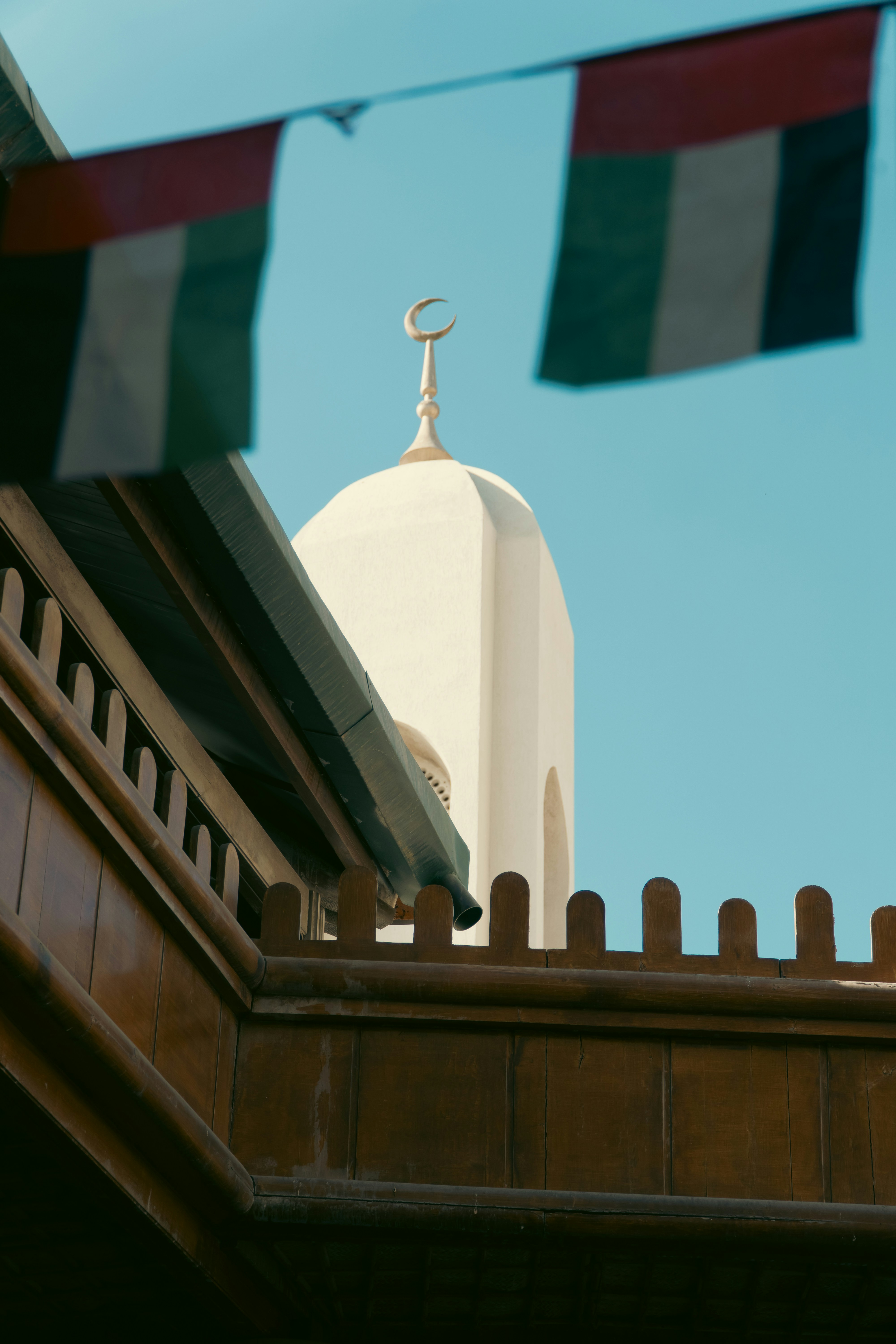 Crescent Spire Rising Behind Prayer Flags and Timber Battlements