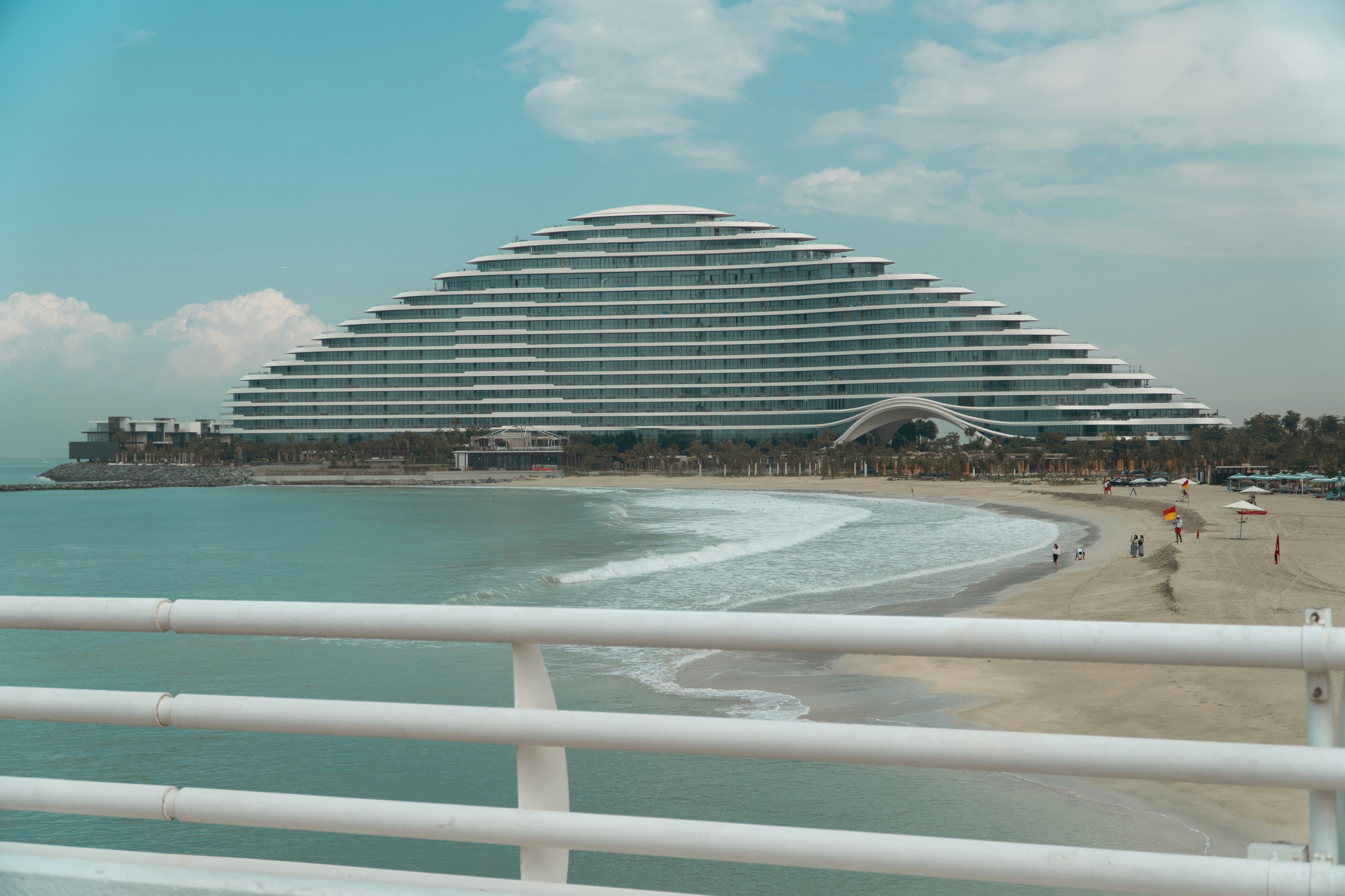 A large building sitting on top of a beach next to the ocean photo ...