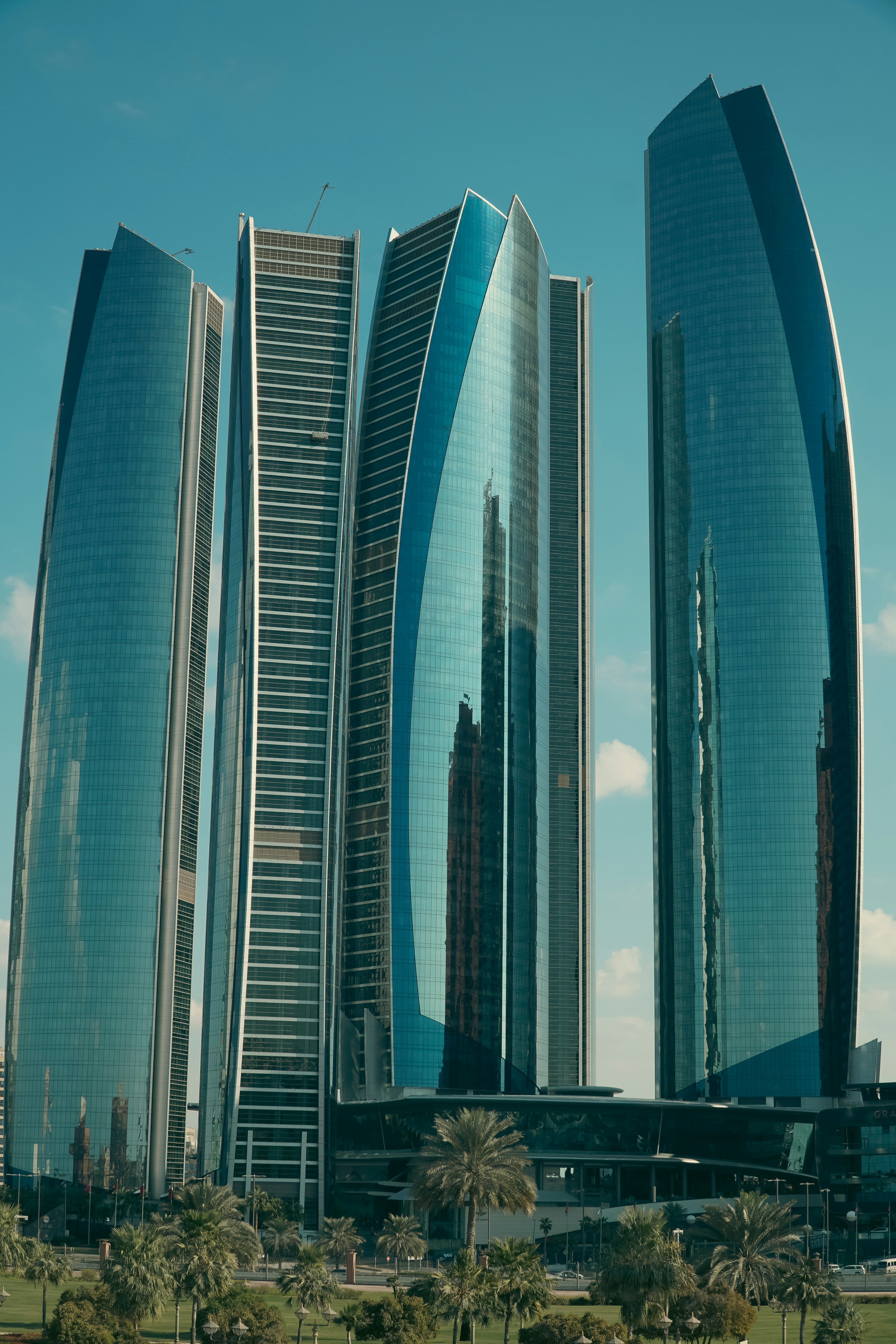 Azure Facades: Curved Glass Towers Rise Above a Palm-Fringed Cityscape