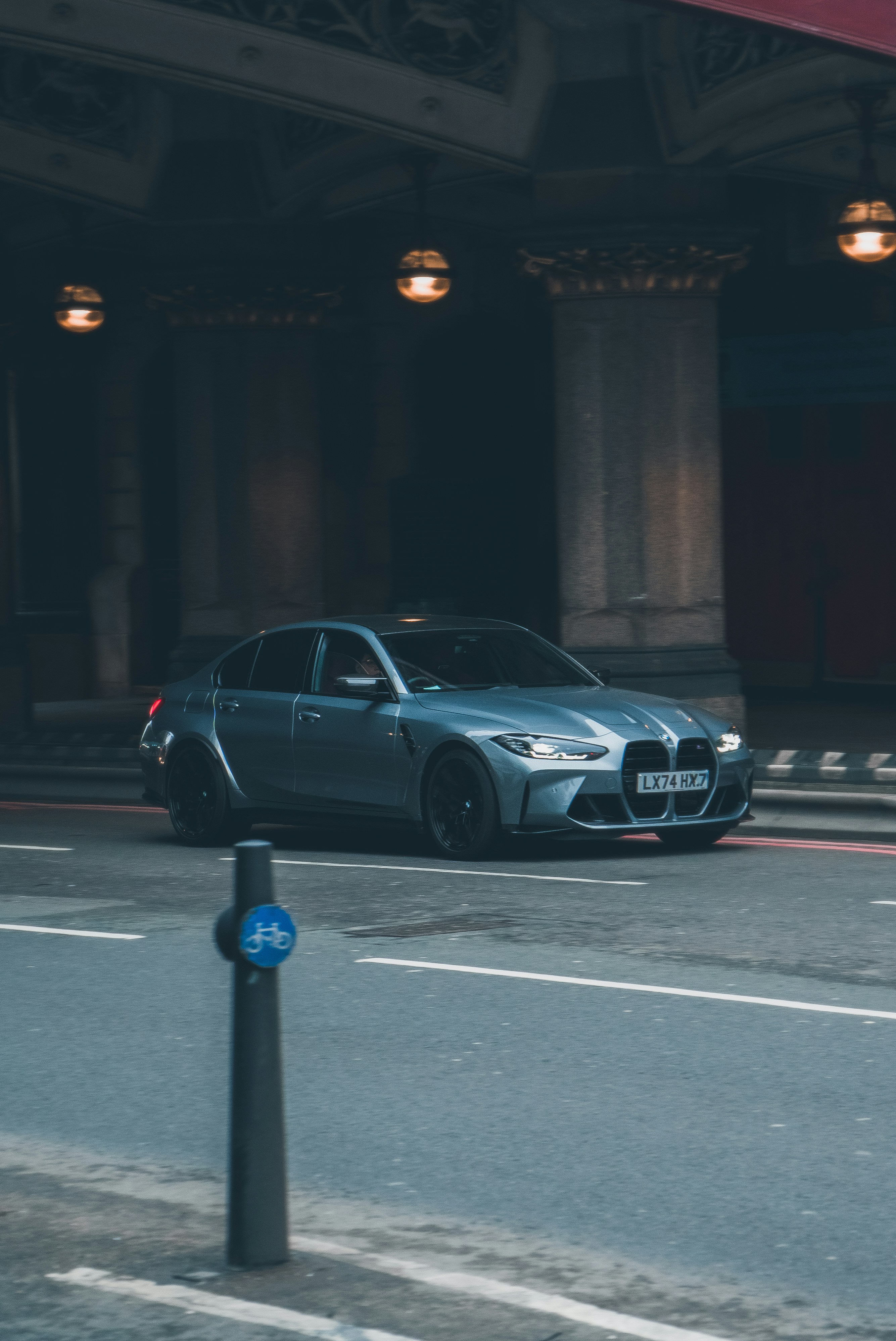 Blue-Silver Sedan Under the City Arcade at Dusk