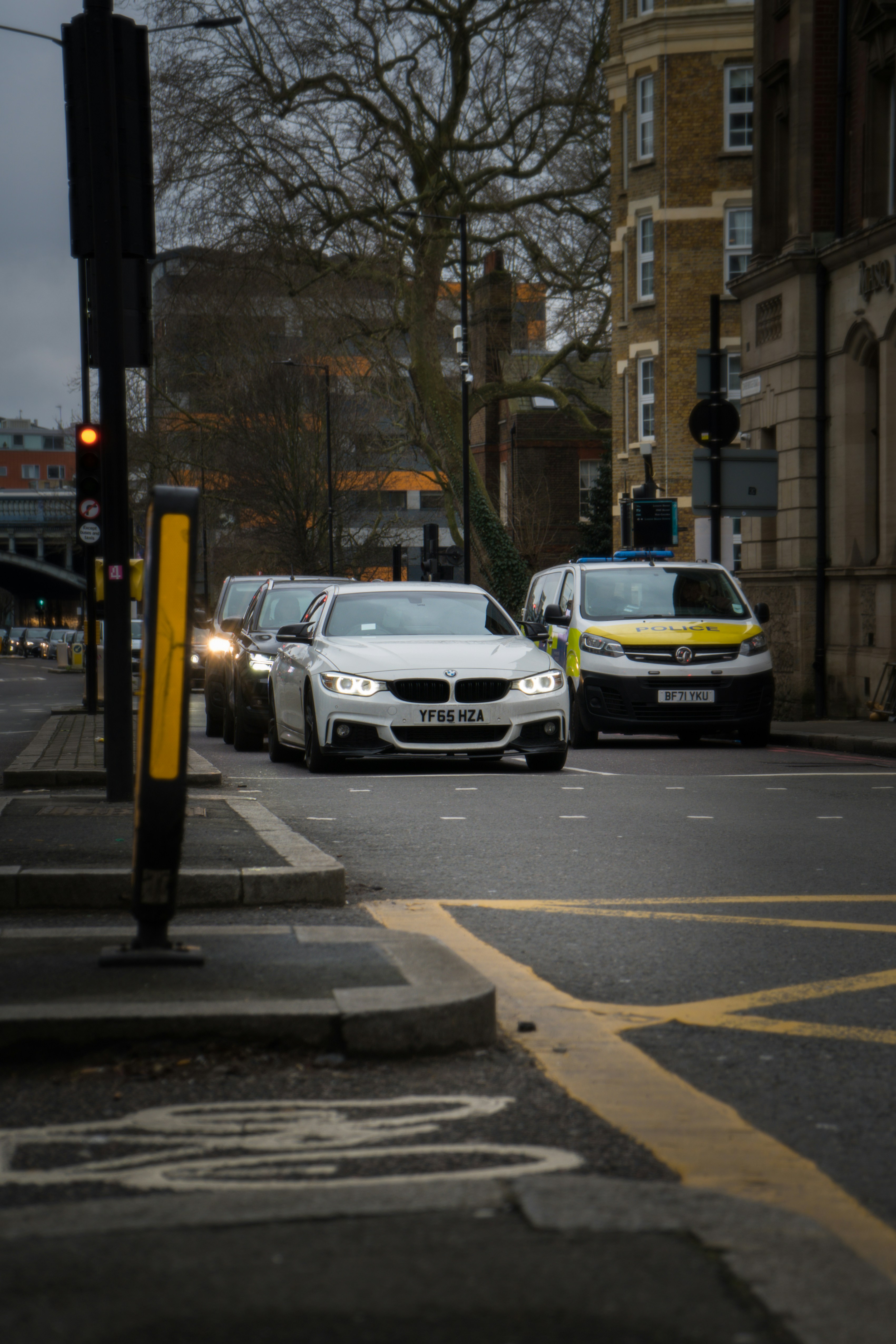 Lead White Sedan Anchors a City Street Convoy