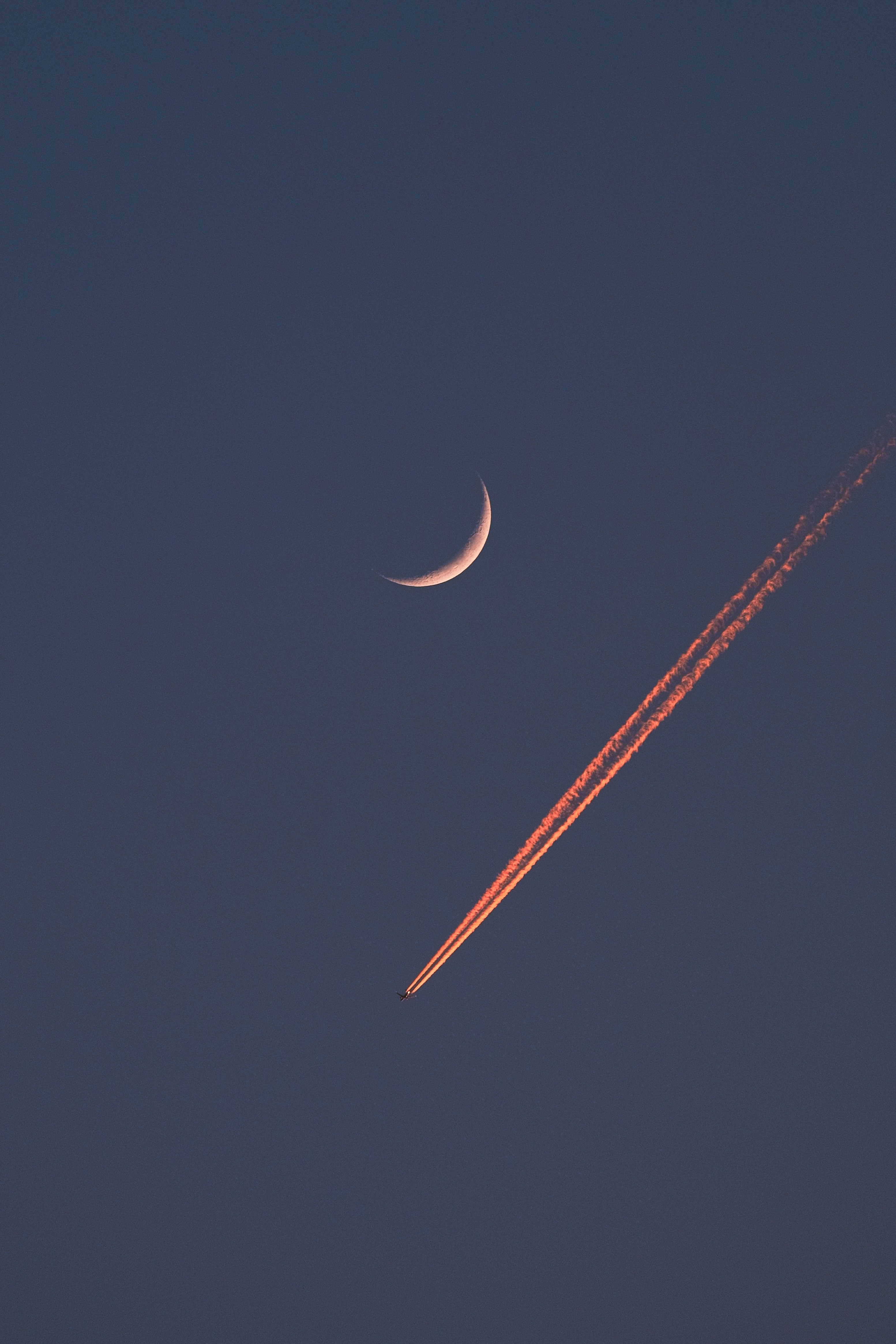 Crescent Moon and Dual Contrails: Dusk Sky in Motion
