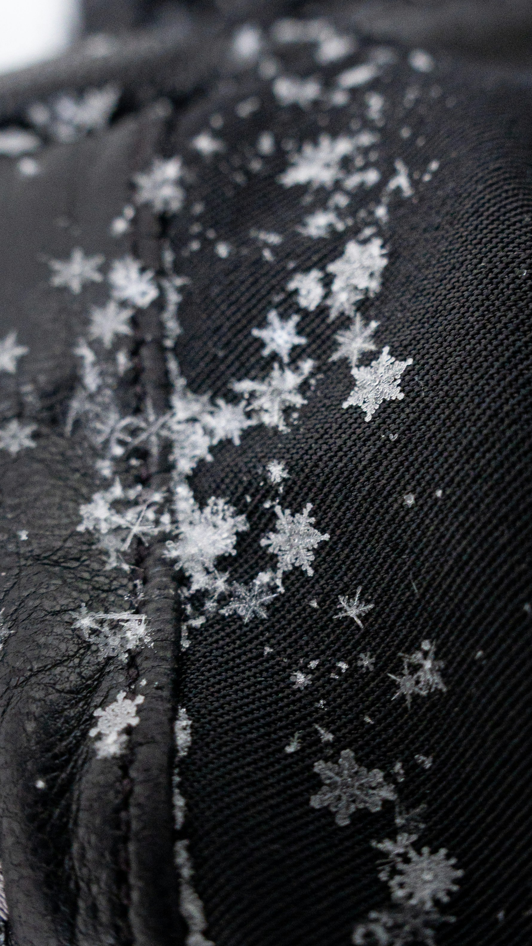 A close up of a black and white backpack with snow flakes on it
