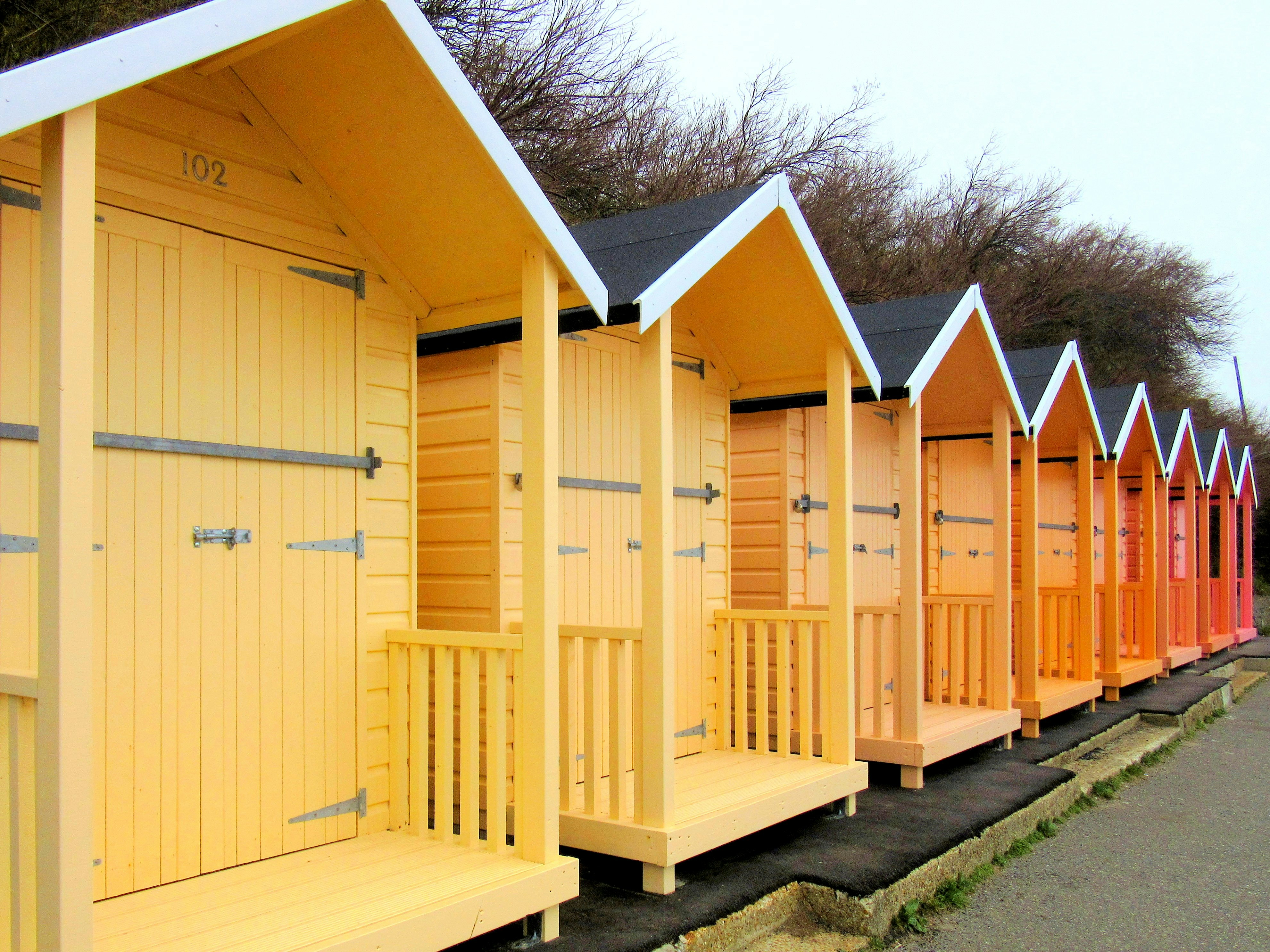 A row of beach huts sitting next to each other photo – Free Hut Image ...