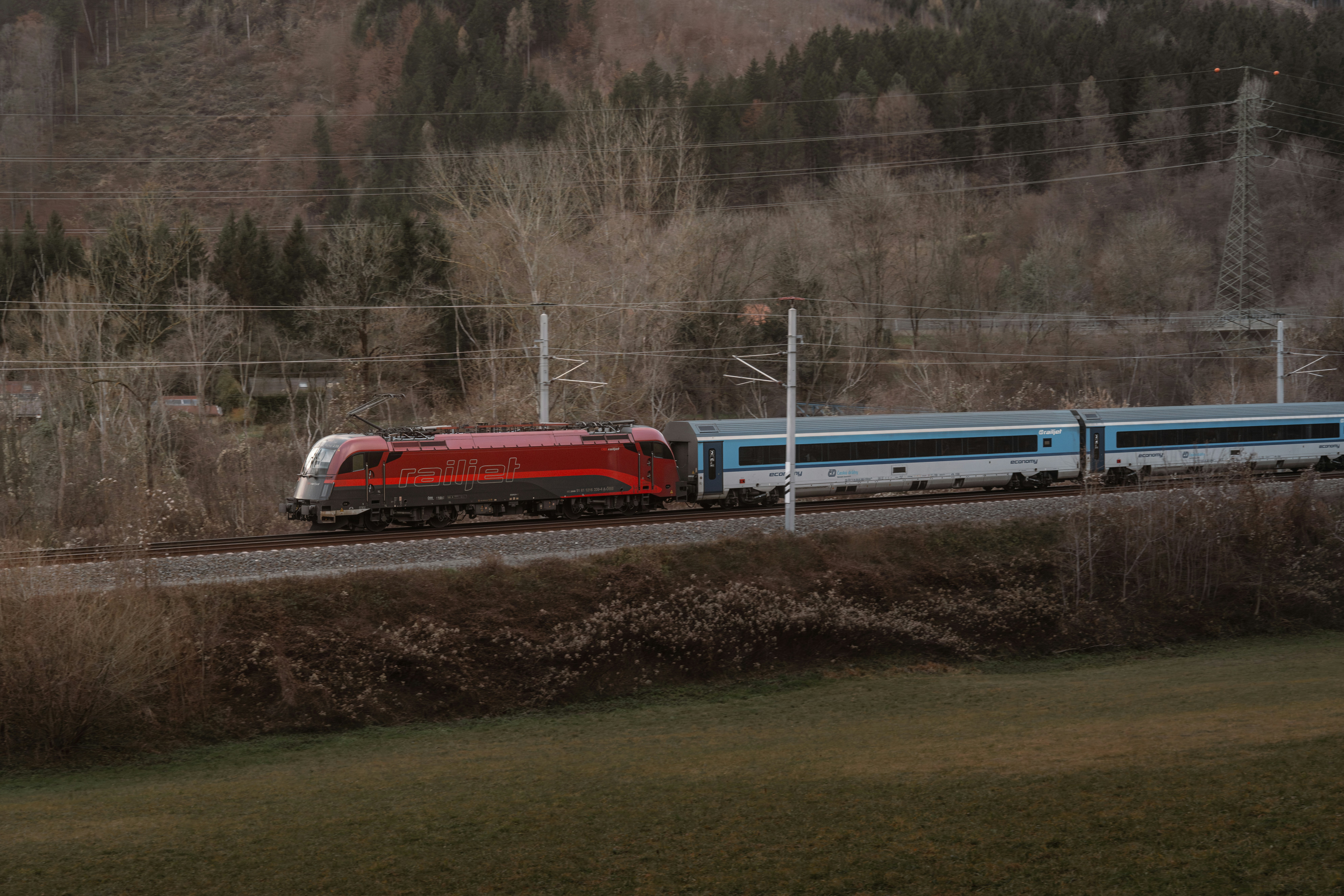 A red and blue train traveling down train tracks photo – Free Train ...