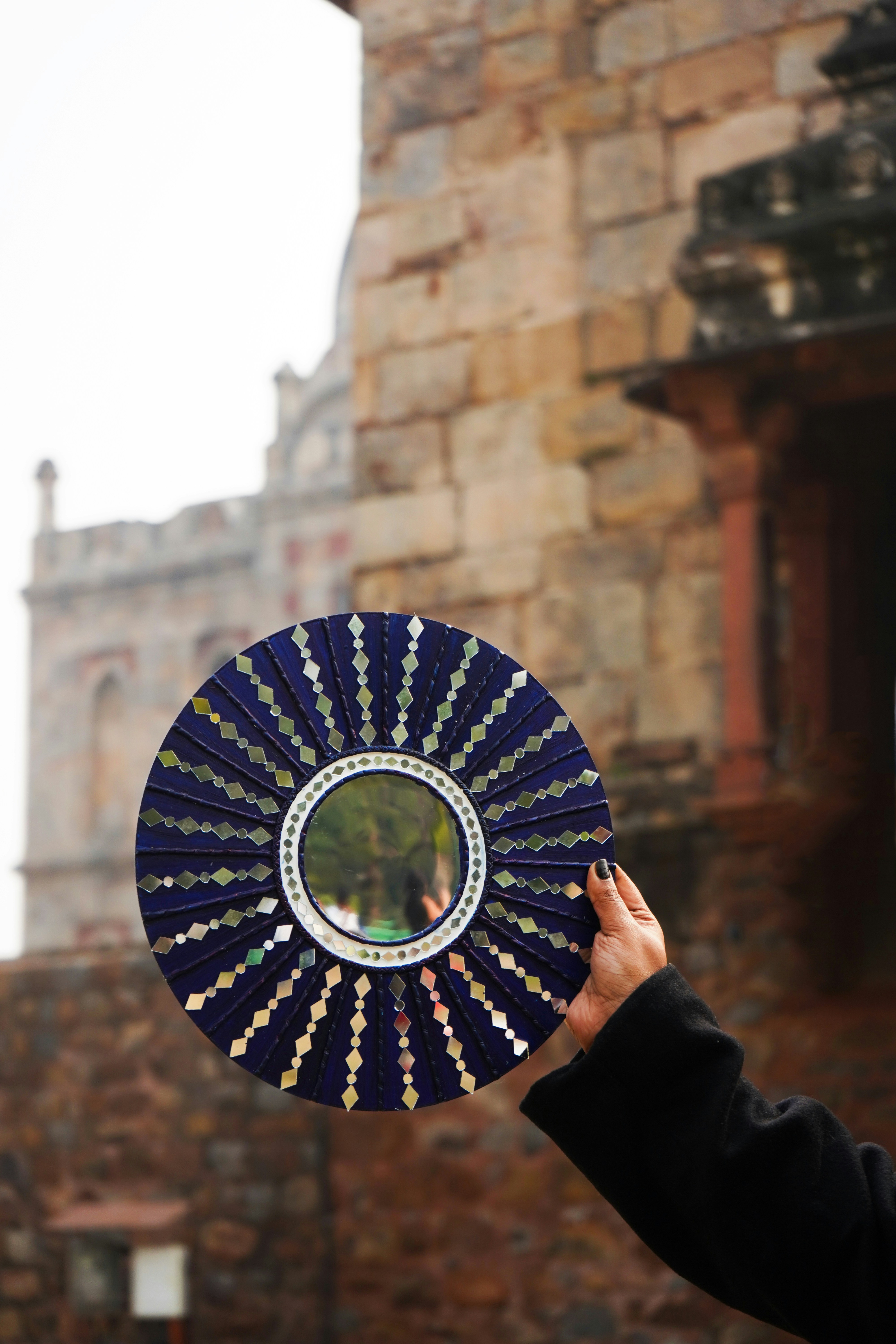 Circle of Reflection: A Hand-Held Mirror Framing an Ancient Facade