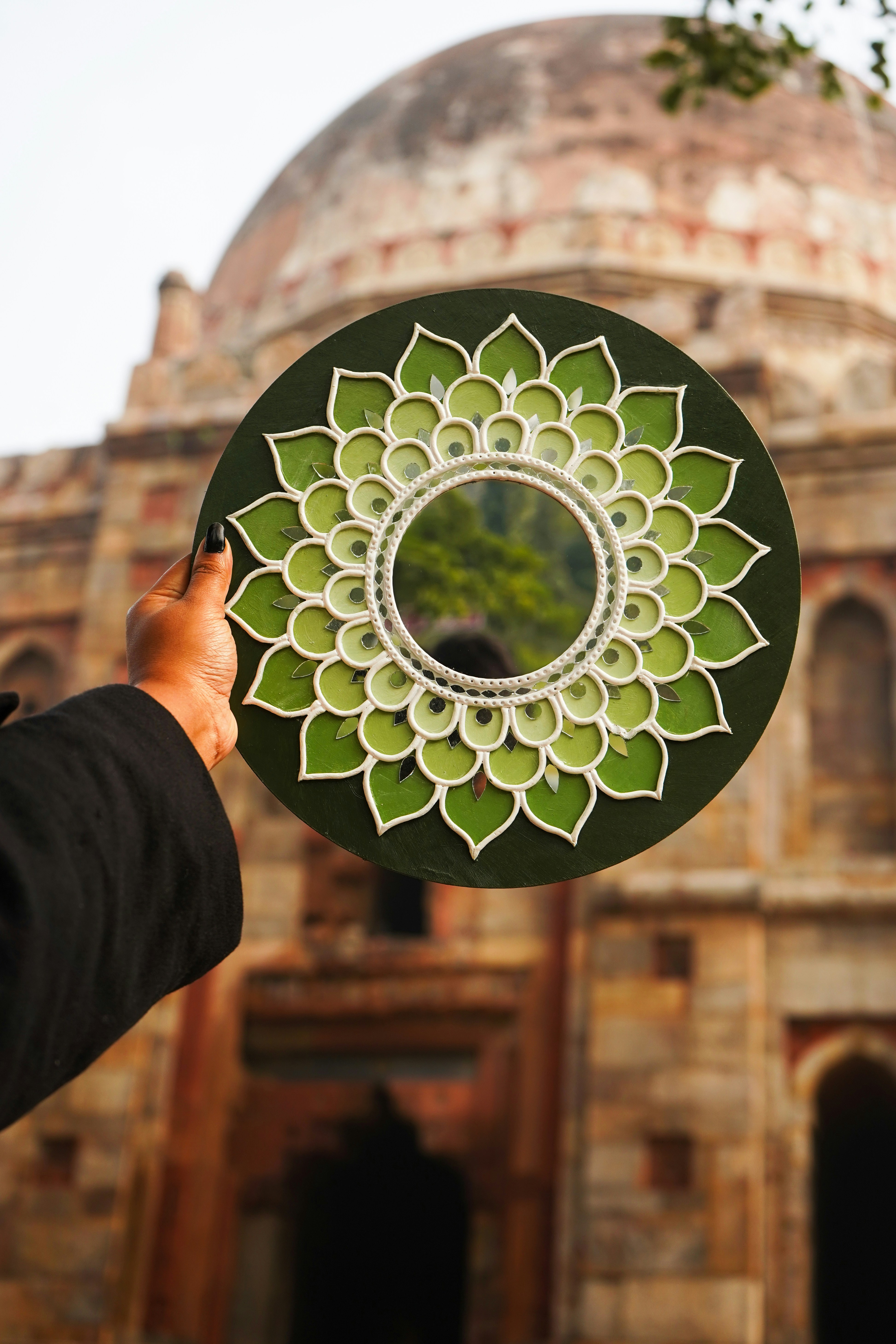 Lattice of Light: A Hand-Held Mandala Framing a Weathered Dome