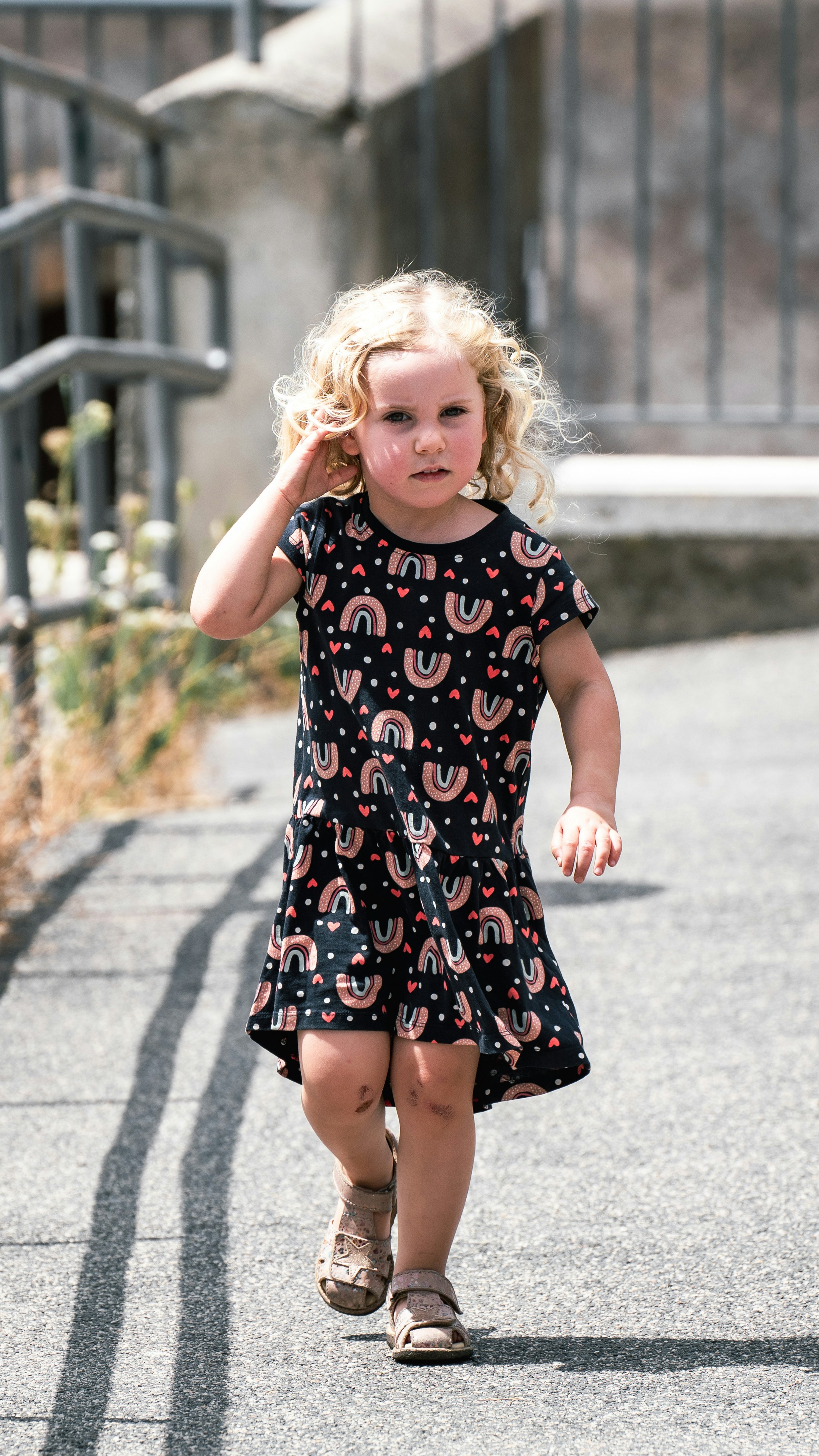 Sunlit Steps: A Young Girl Finds Confidence on the Concrete Path
