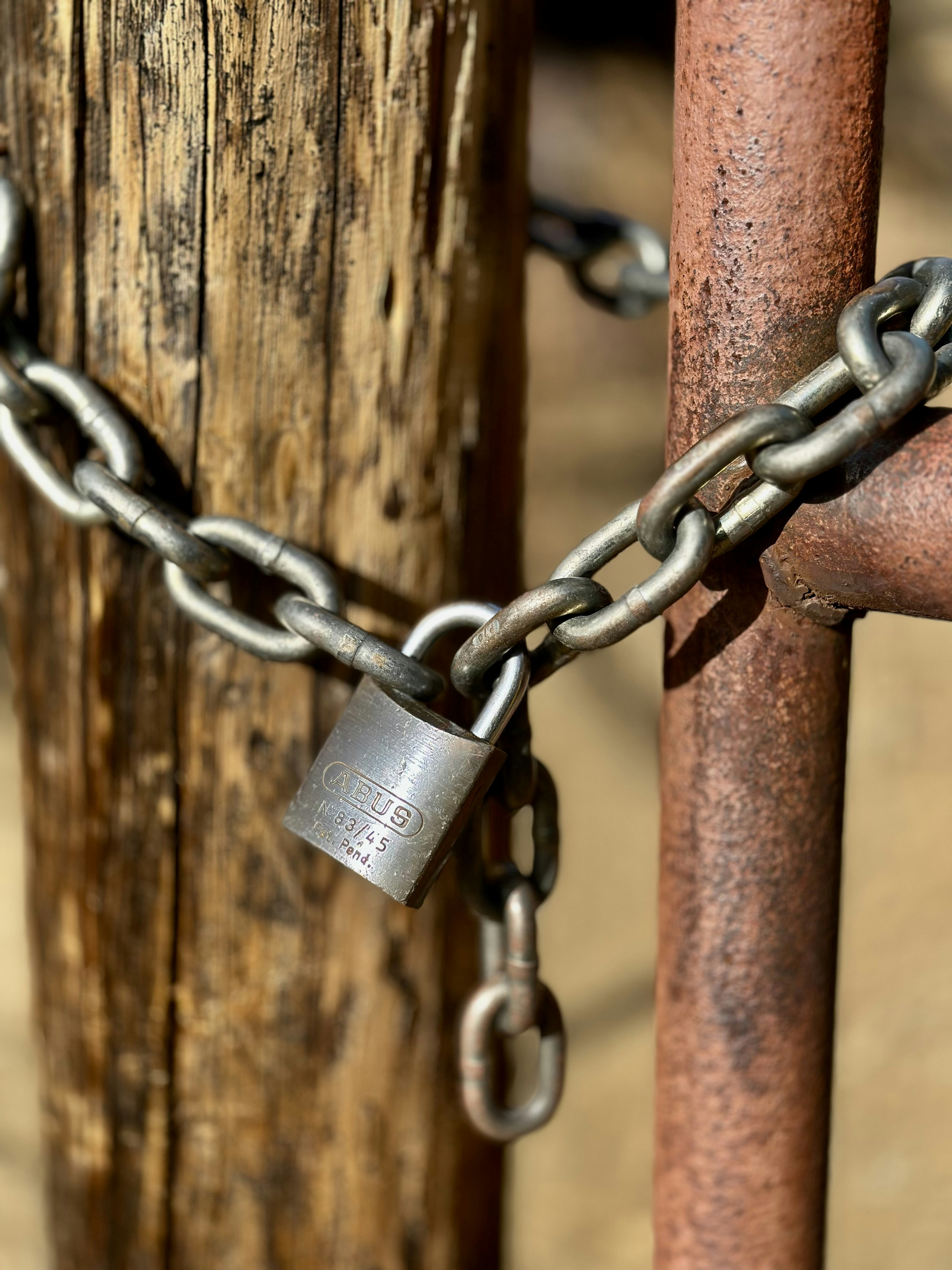 A close up of a chain and padlock on a wooden post photo – Free Rust ...