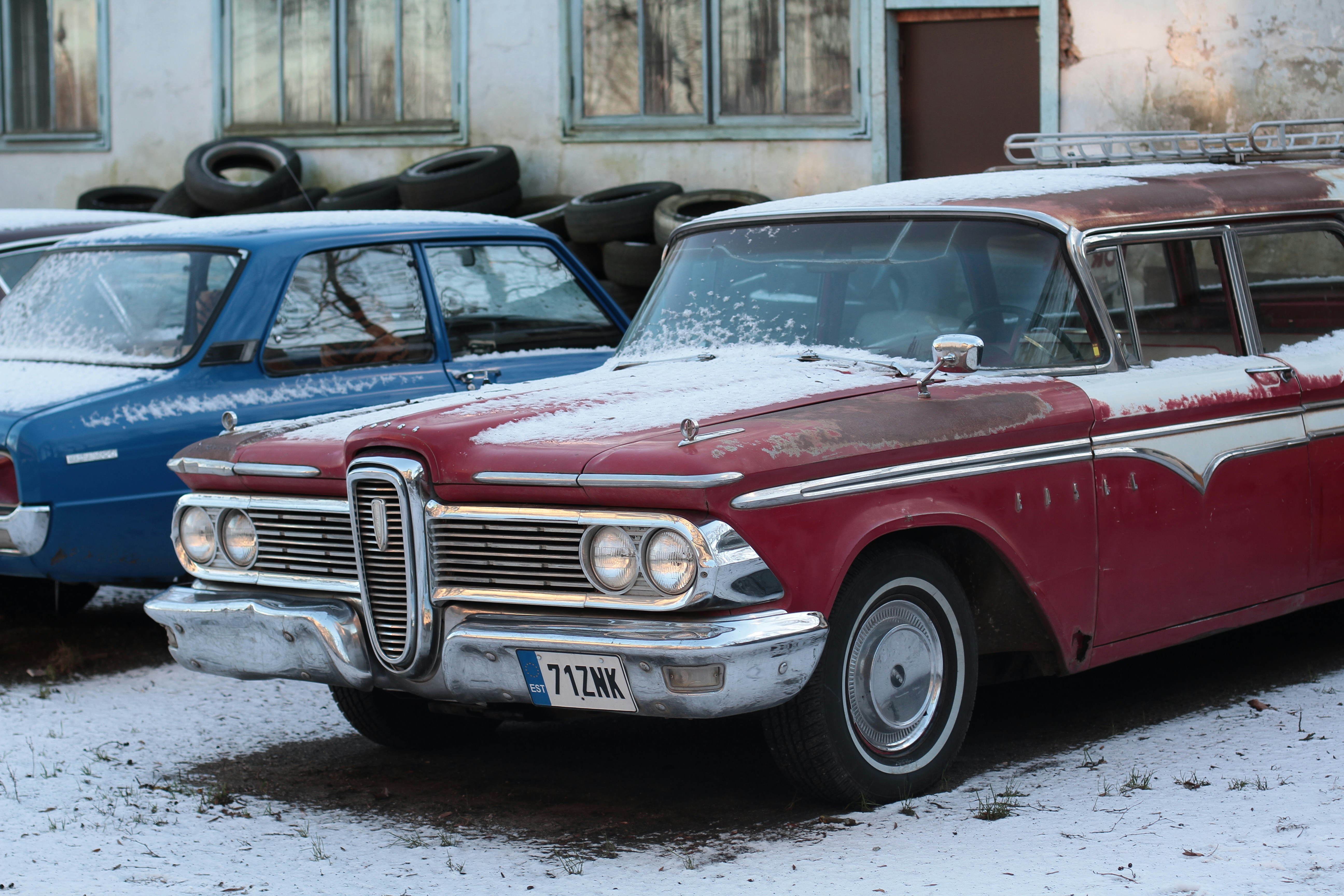 Crimson Classic in Frost: A Vintage Sedan Resting Among Snow and Chrome