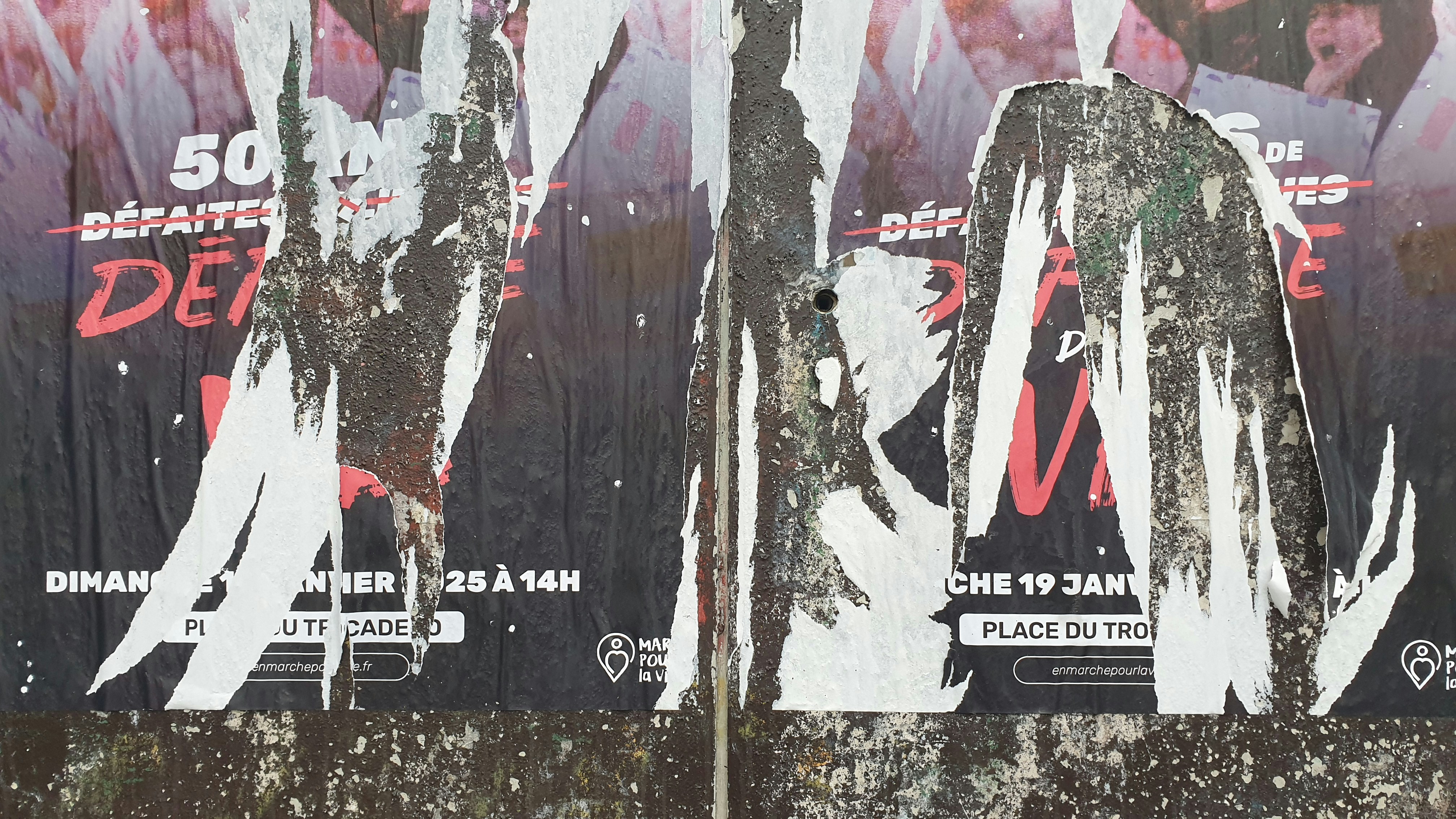 A bunch of posters on the side of a building photo – Free Background ...