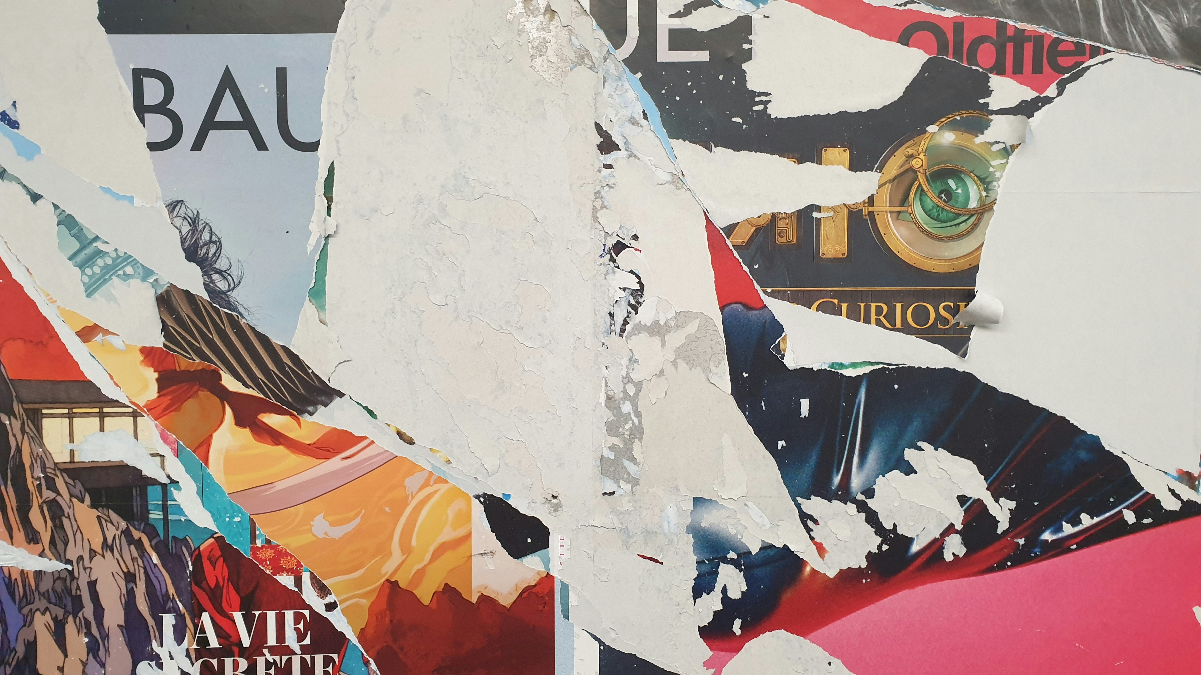 A wall with a bunch of posters on it photo – Free Worn Image on Unsplash