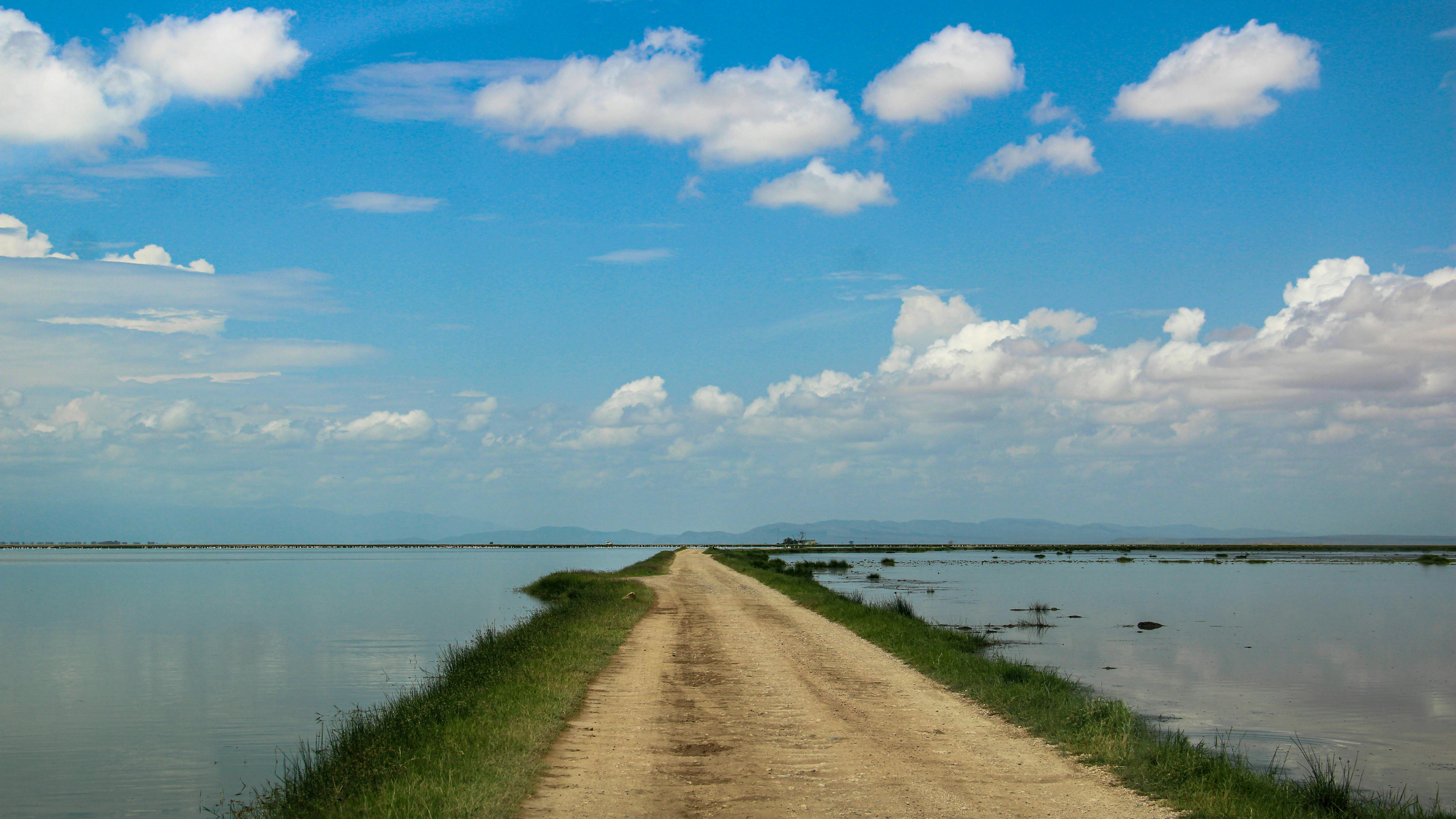 A dirt road that is next to a body of water photo – Free Kenya Image on ...