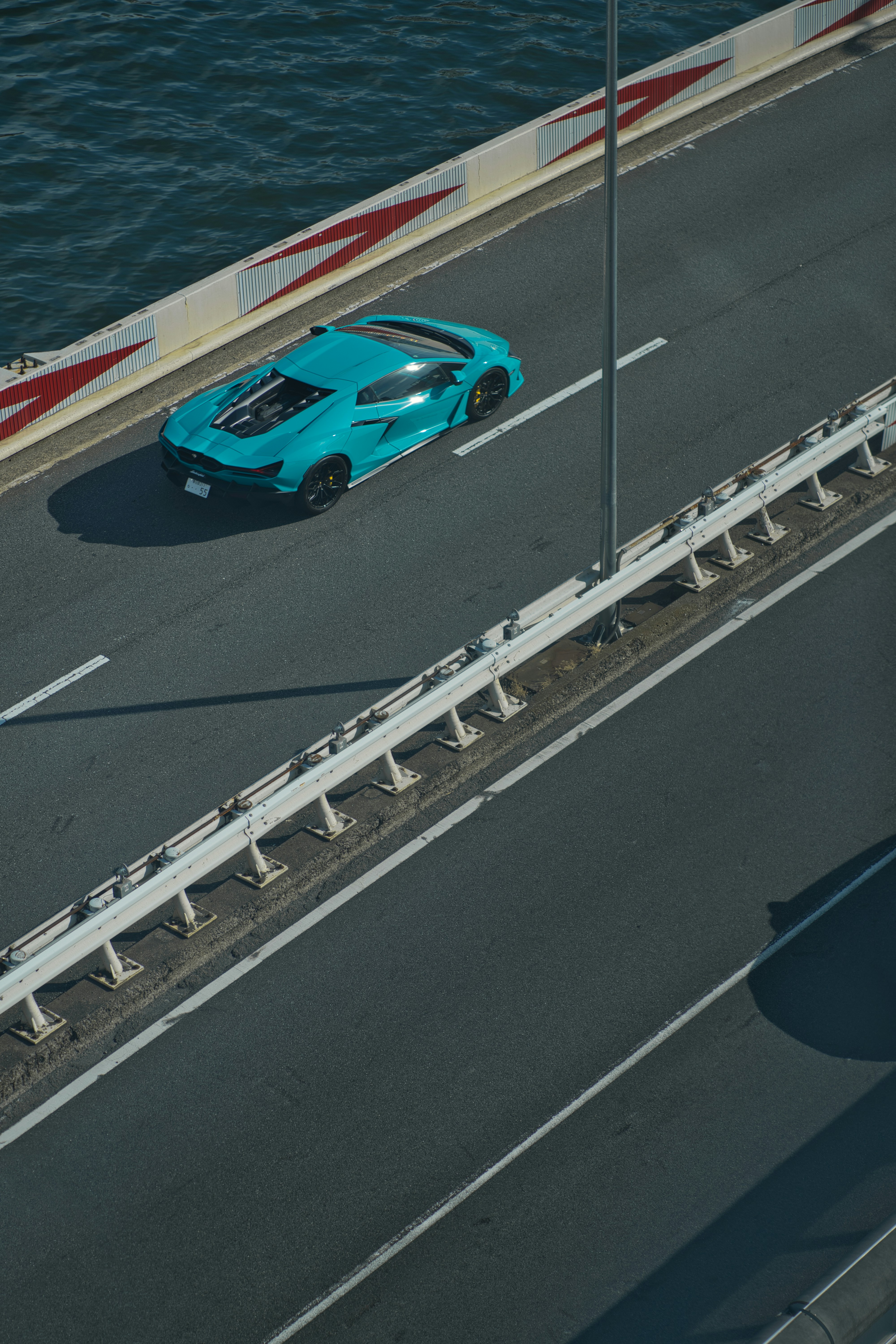Teal Supercar on a Coastal Highway: Silver Guardrails and Long Shadows