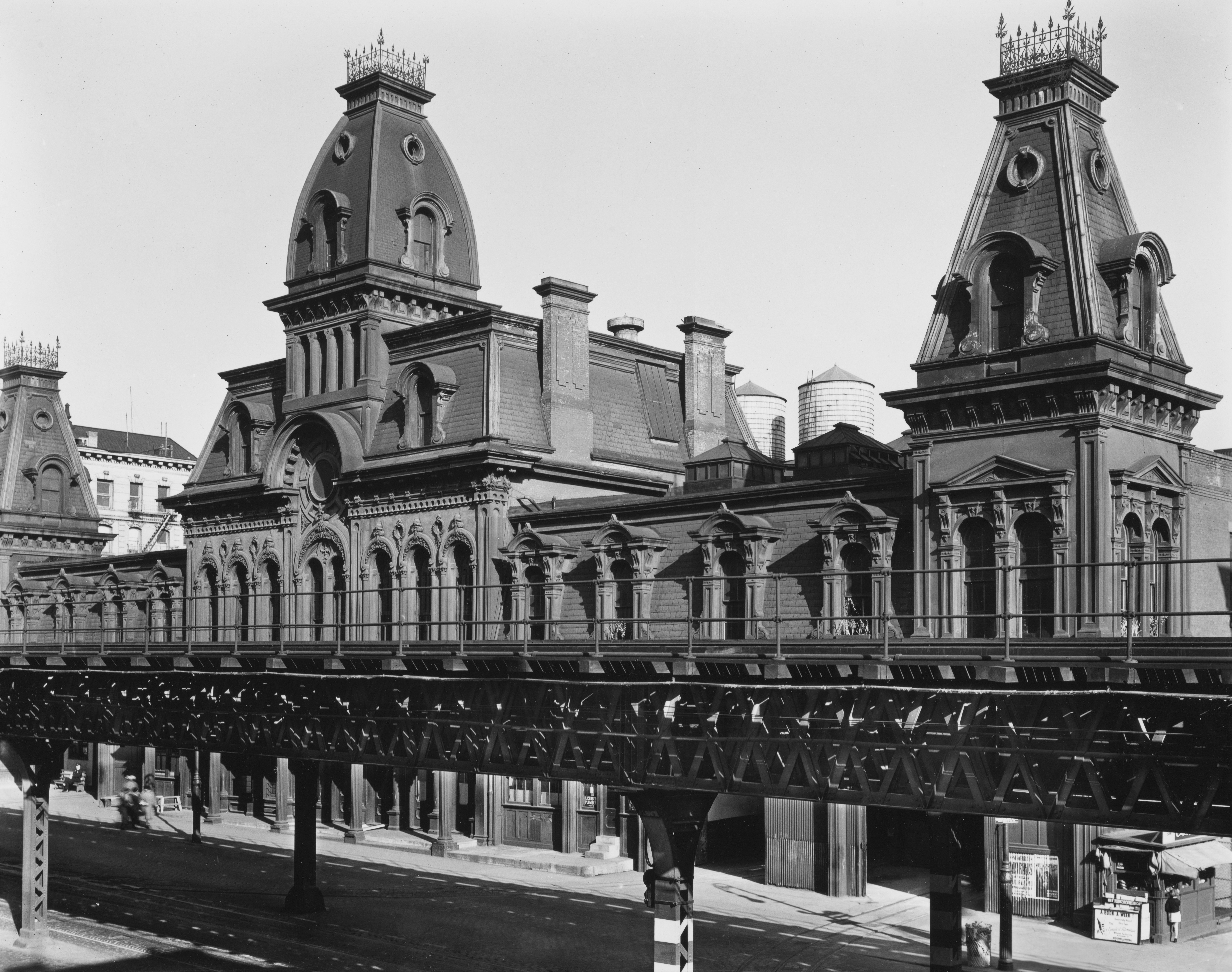 Historic train station with intricate architectural details and elevated railway structure, emphasizing depth and symmetry.