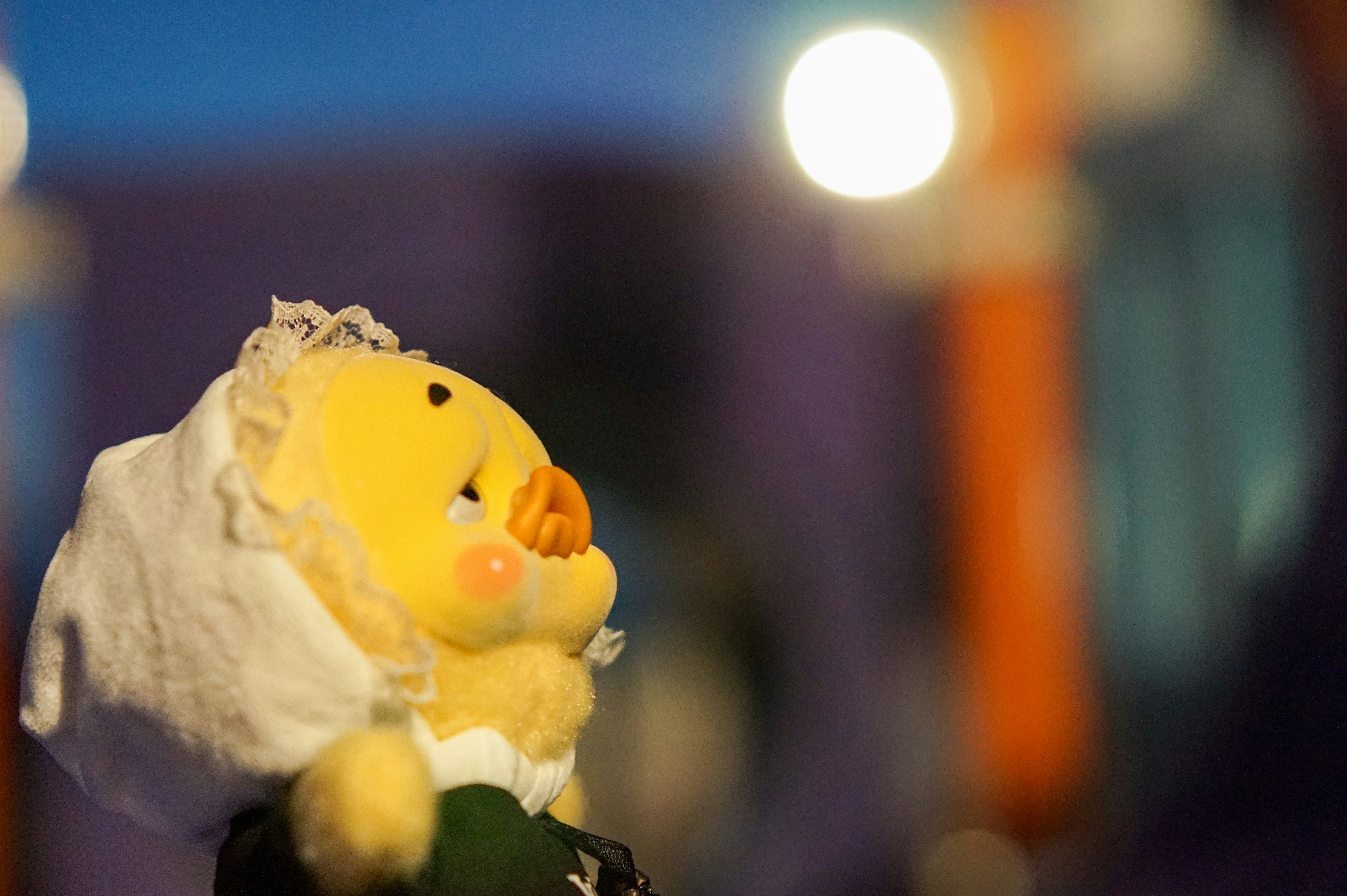 Plush Reveal: A Yellow-Faced Toy Emerges from Snowy White Frill