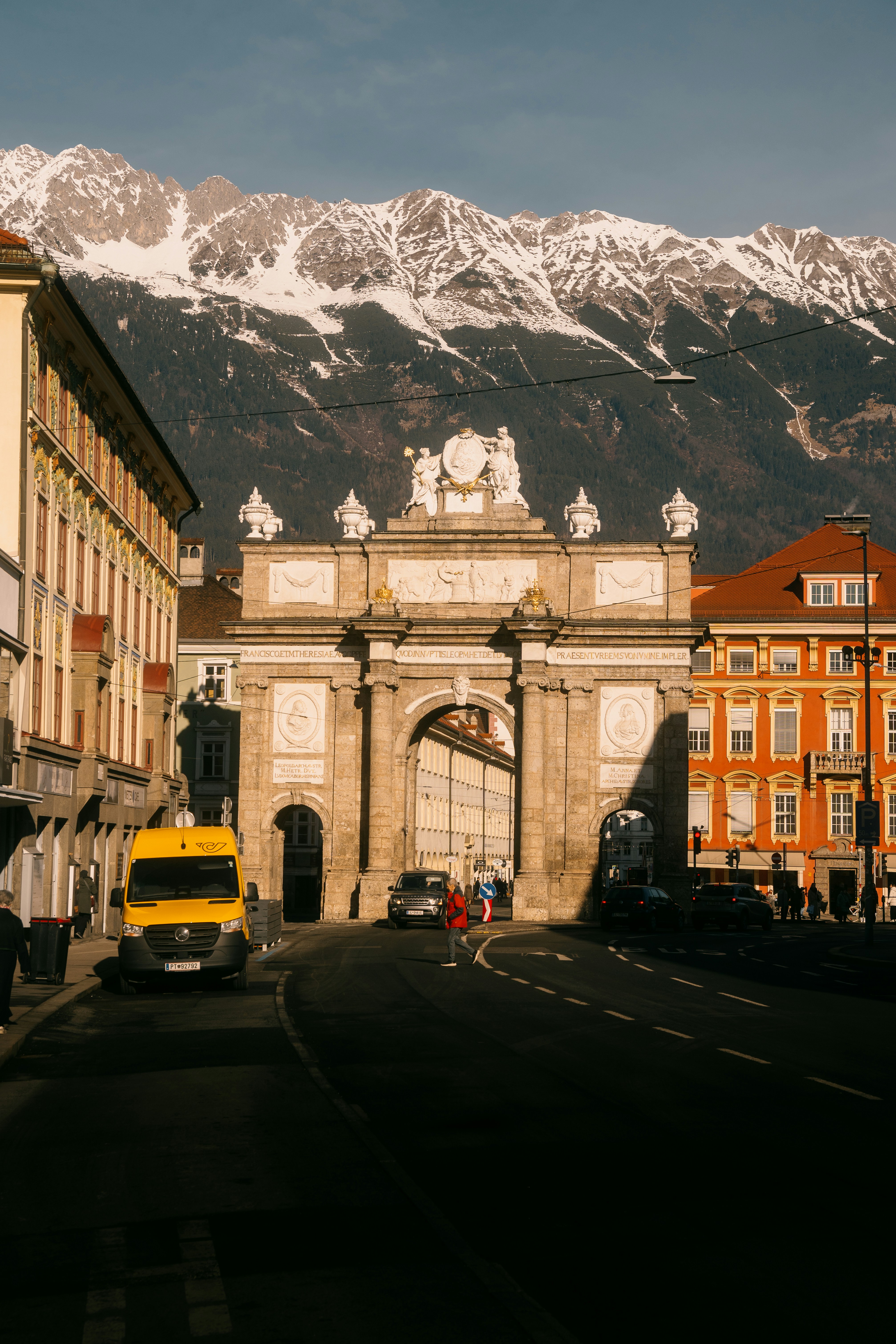 A yellow bus driving down a street next to tall buildings photo – Free ...
