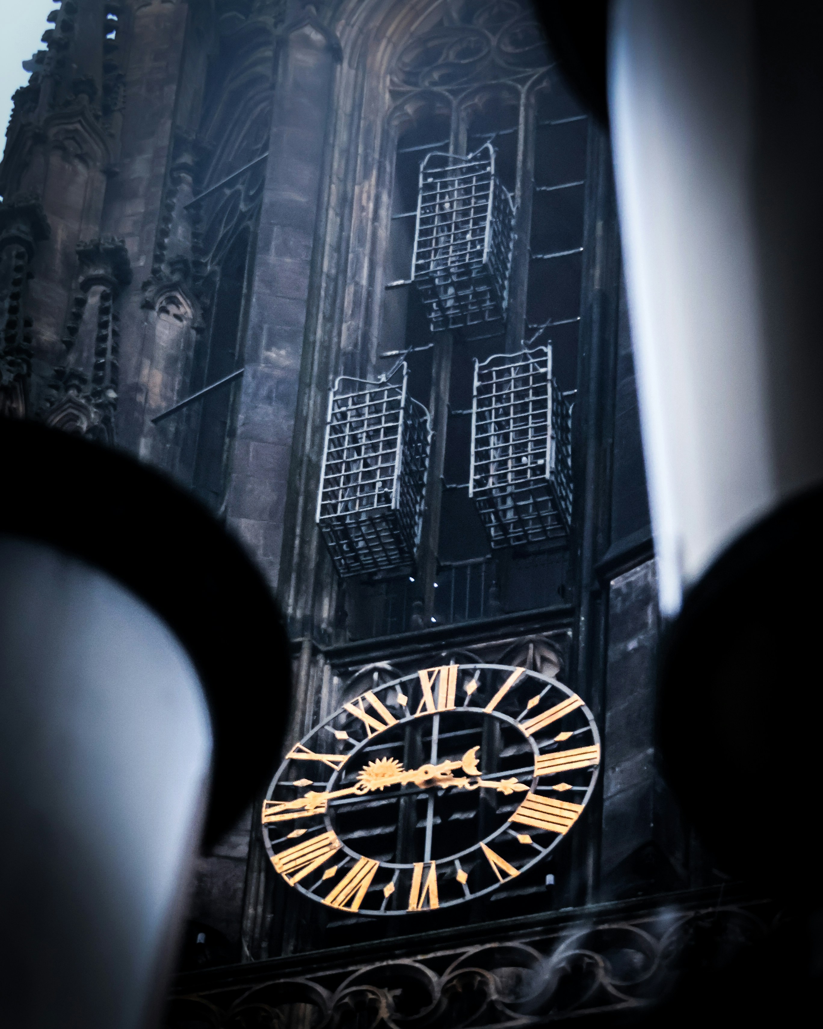 Timekeeper in the Dark: Gothic Clock Amid Grilles