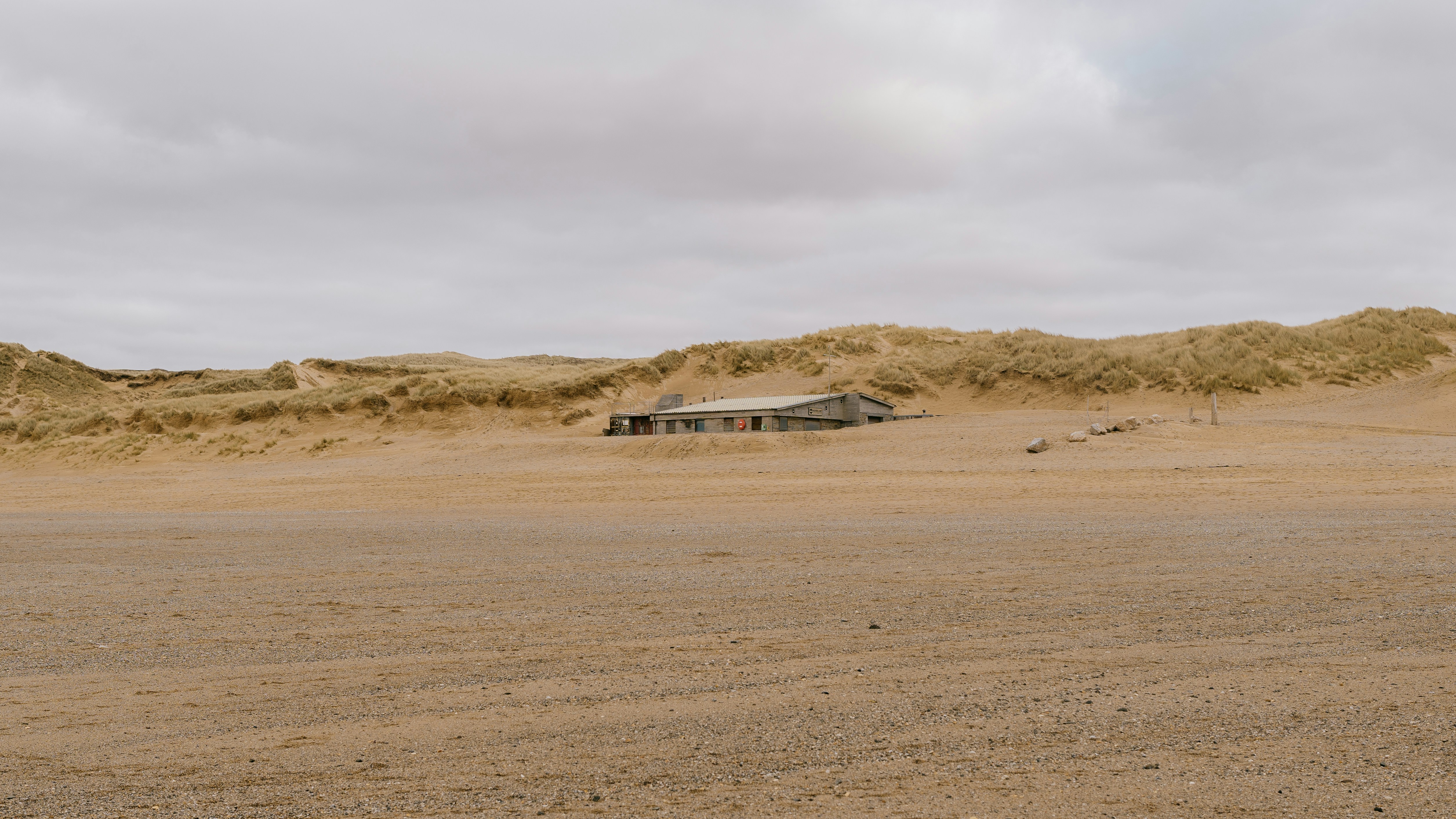Desert Outpost: A Lone Structure Among Quiet Dunes
