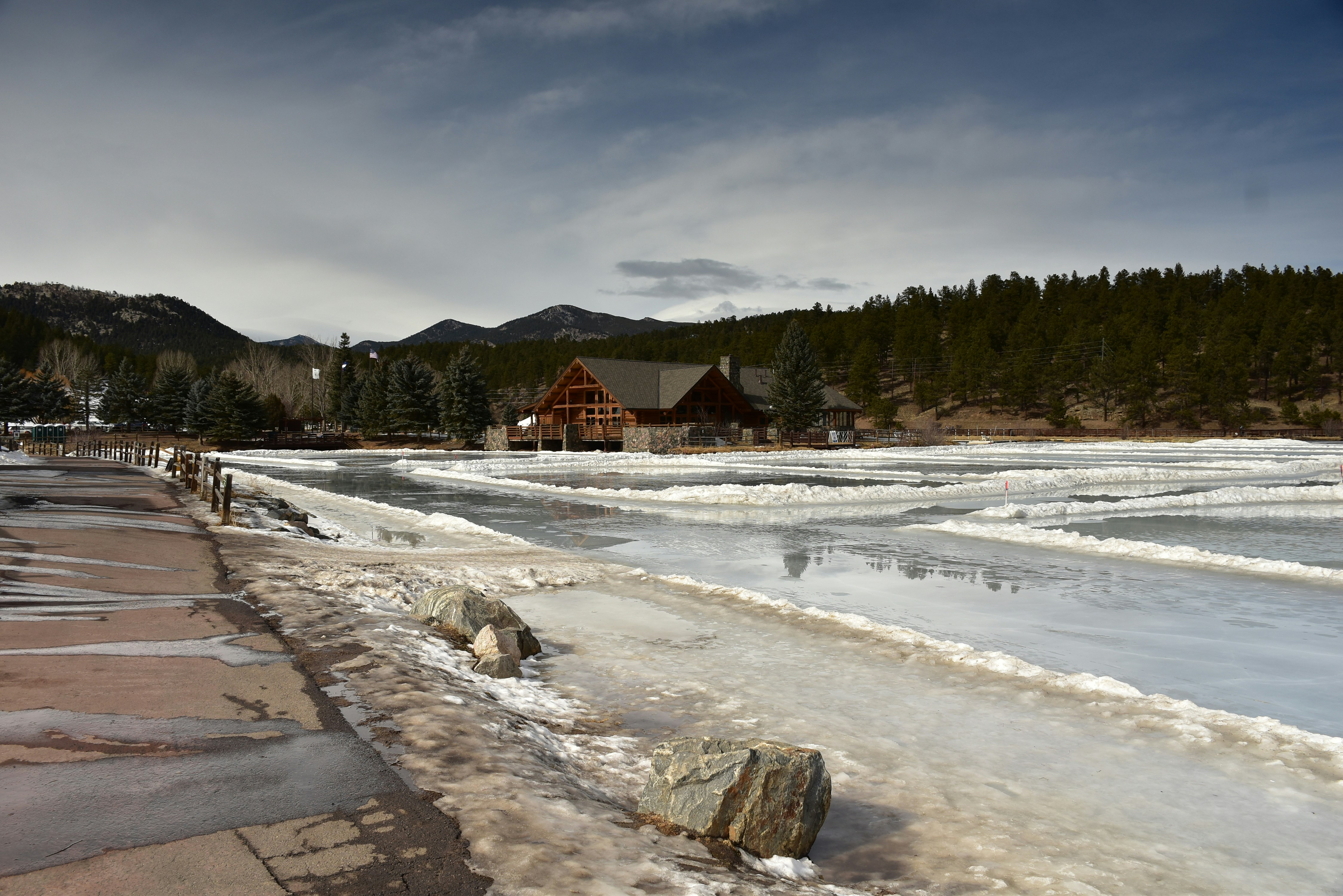 A long stretch of frozen water next to a forest photo – Free Nature ...