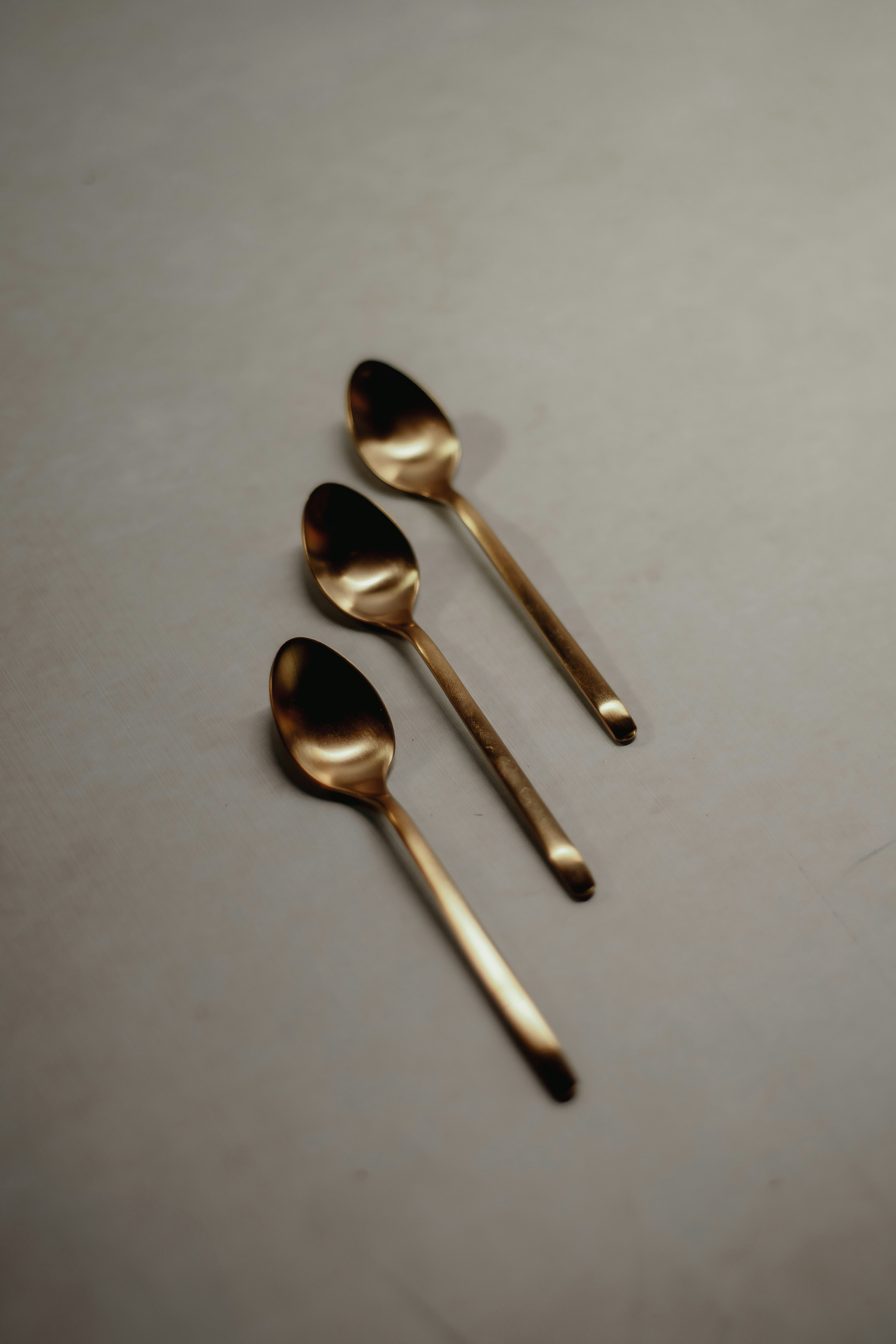 A group of three spoons sitting on top of a table photo – Free Spoon ...