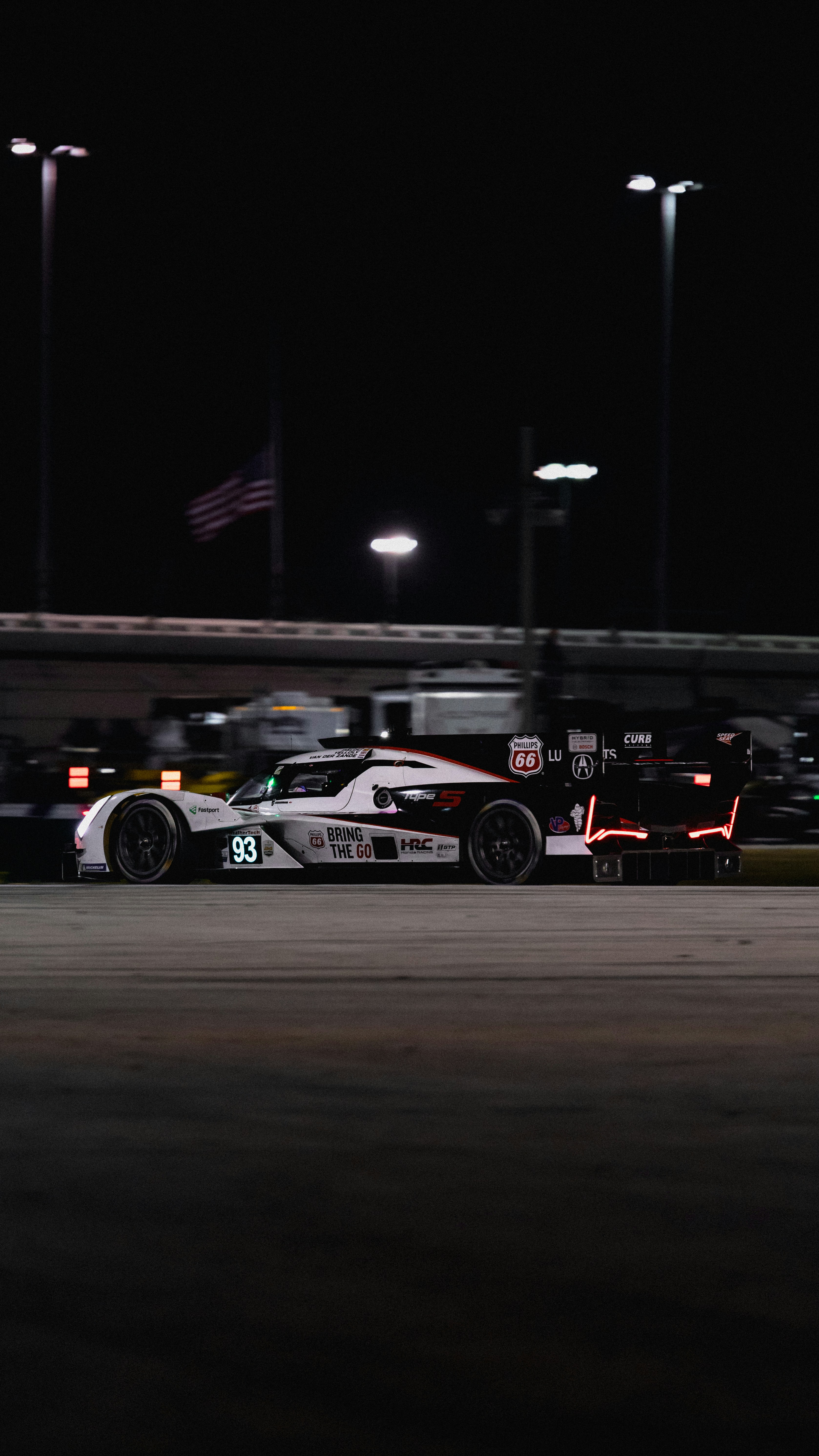 A race car driving down a race track at night photo – Free Usa Image on ...