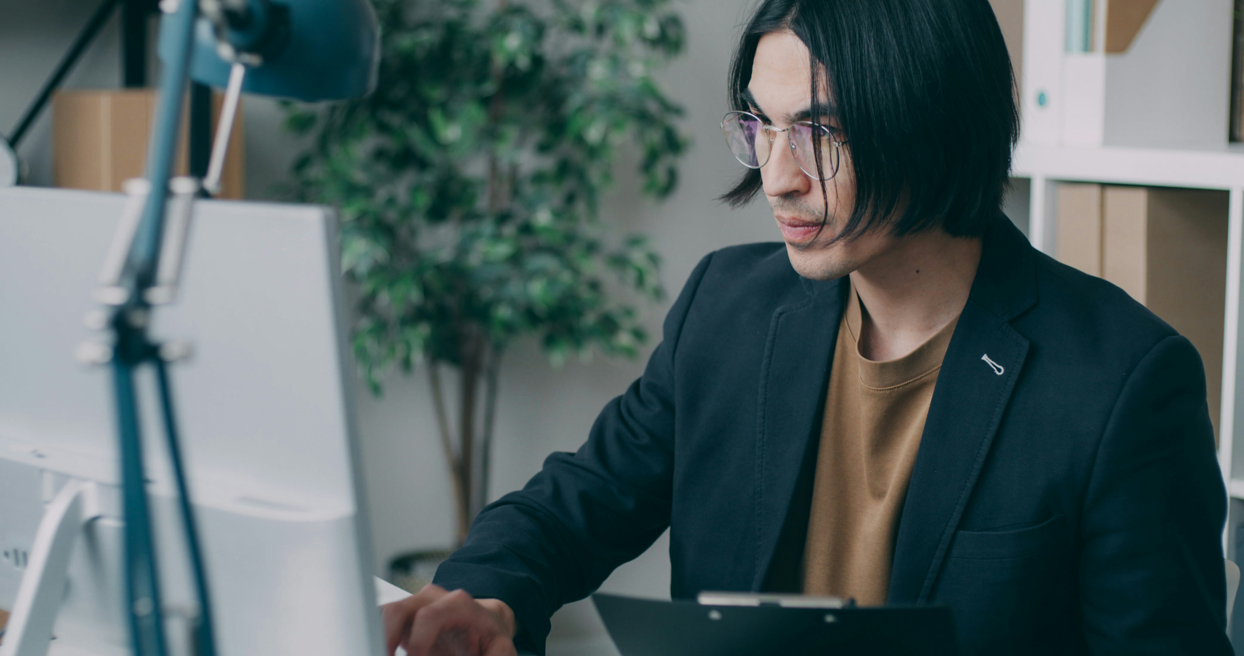 A man sitting at a desk in front of a computer photo – Free Woman Image ...