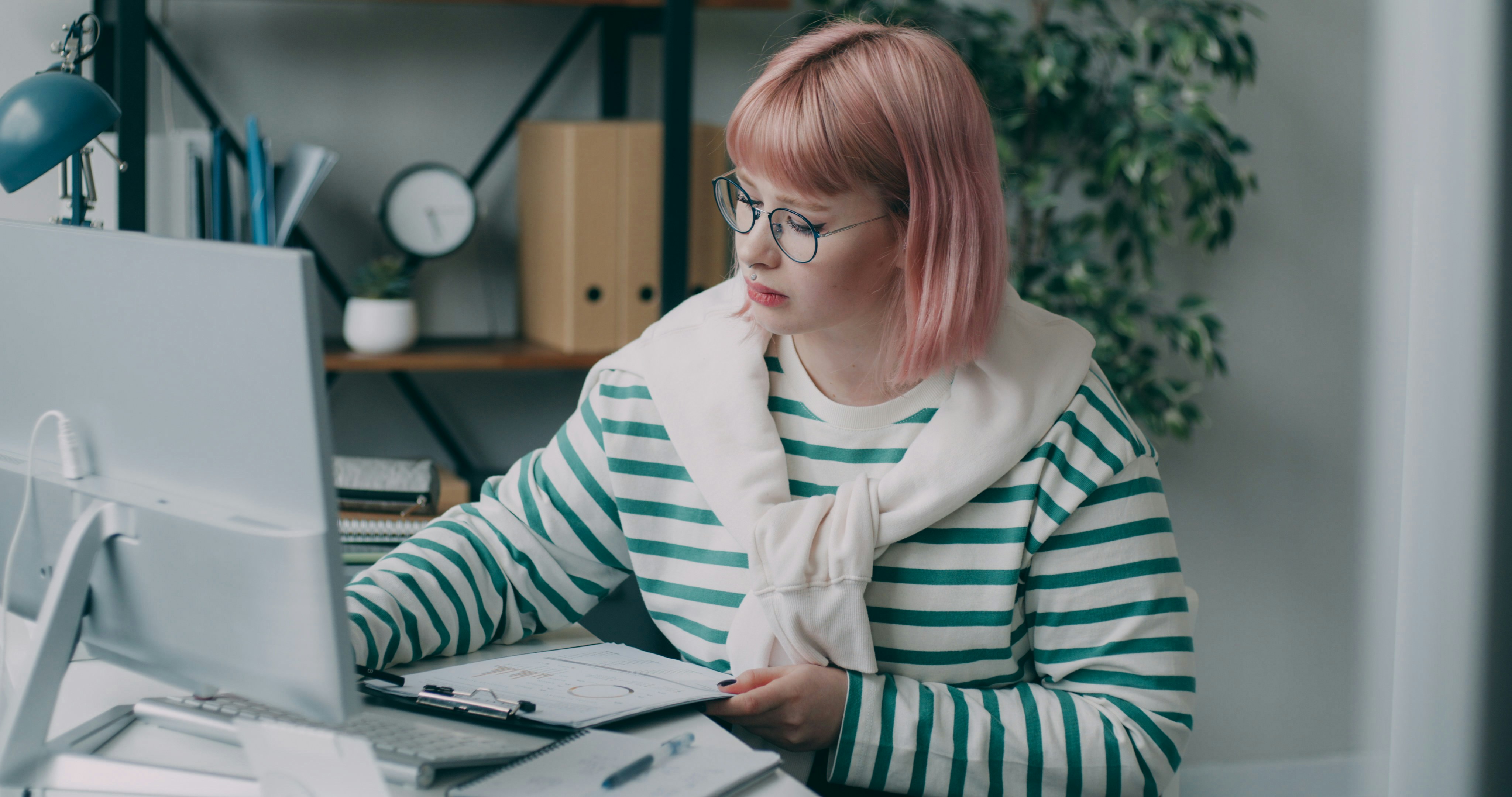 A woman sitting at a desk working on a computer photo – Free Adult ...