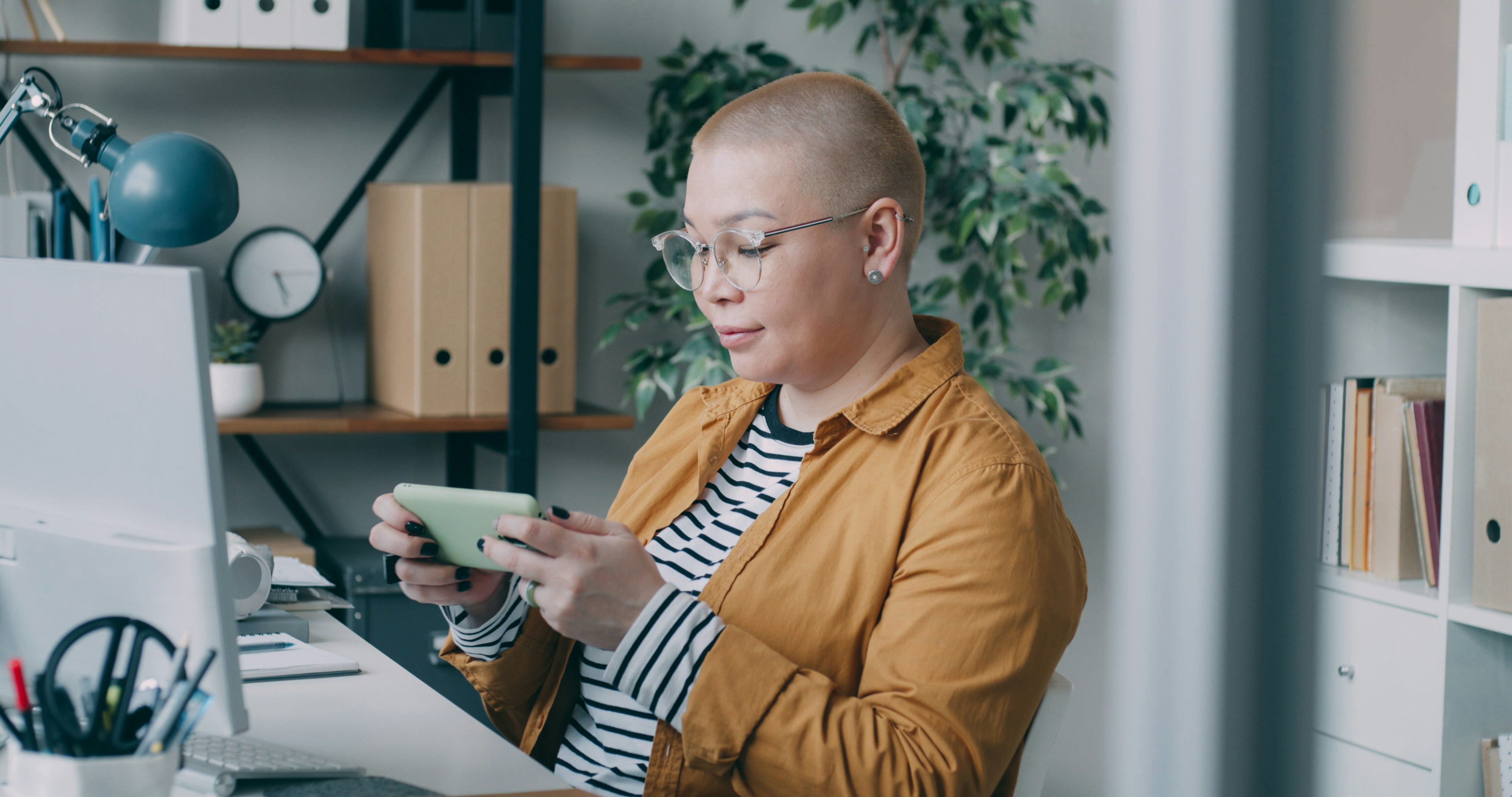 A man sitting at a desk using a cell phone photo – Free Man Image on ...