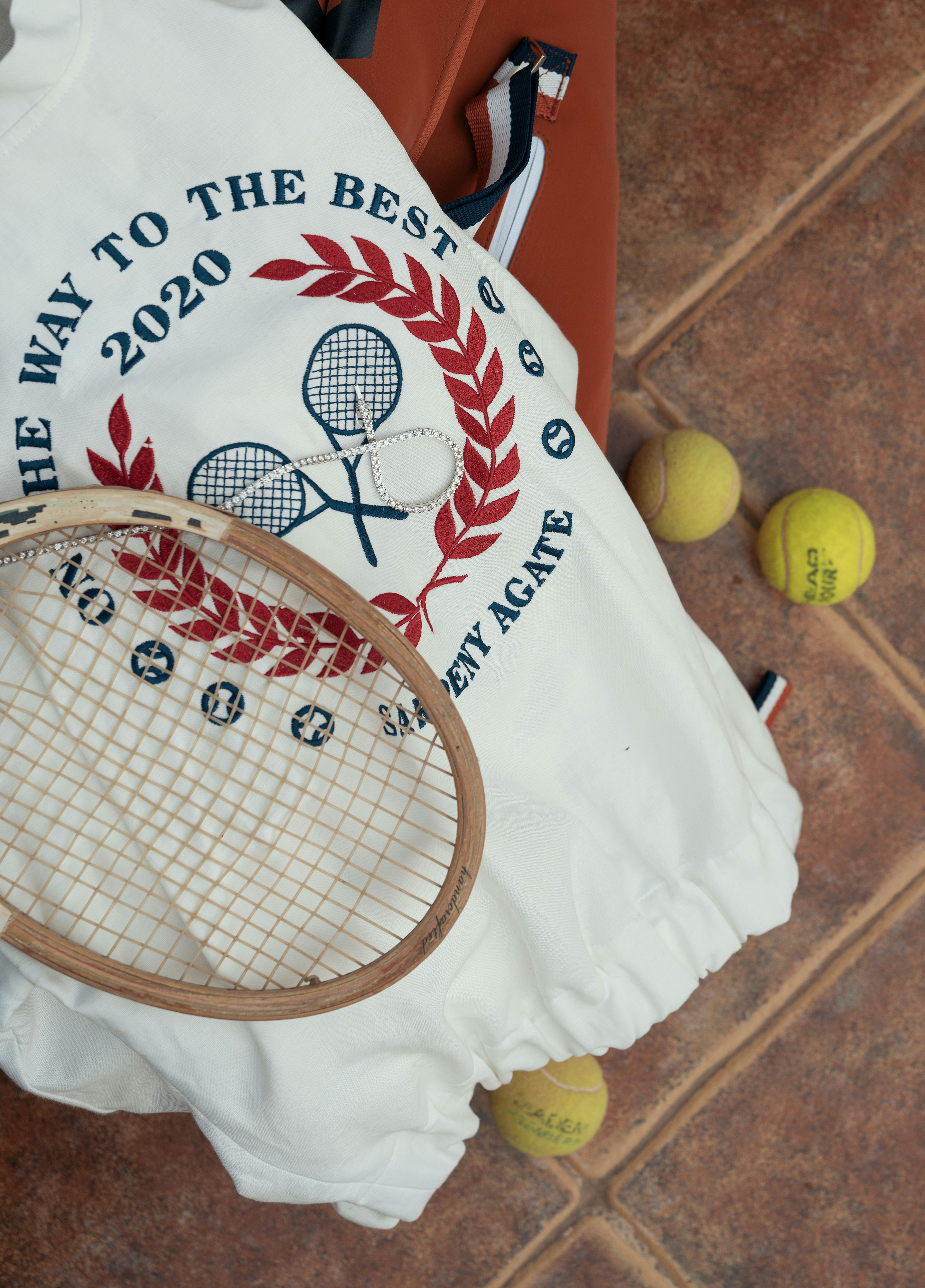 A tennis racket and a t - shirt on a tile floor photo – Free Fashion ...
