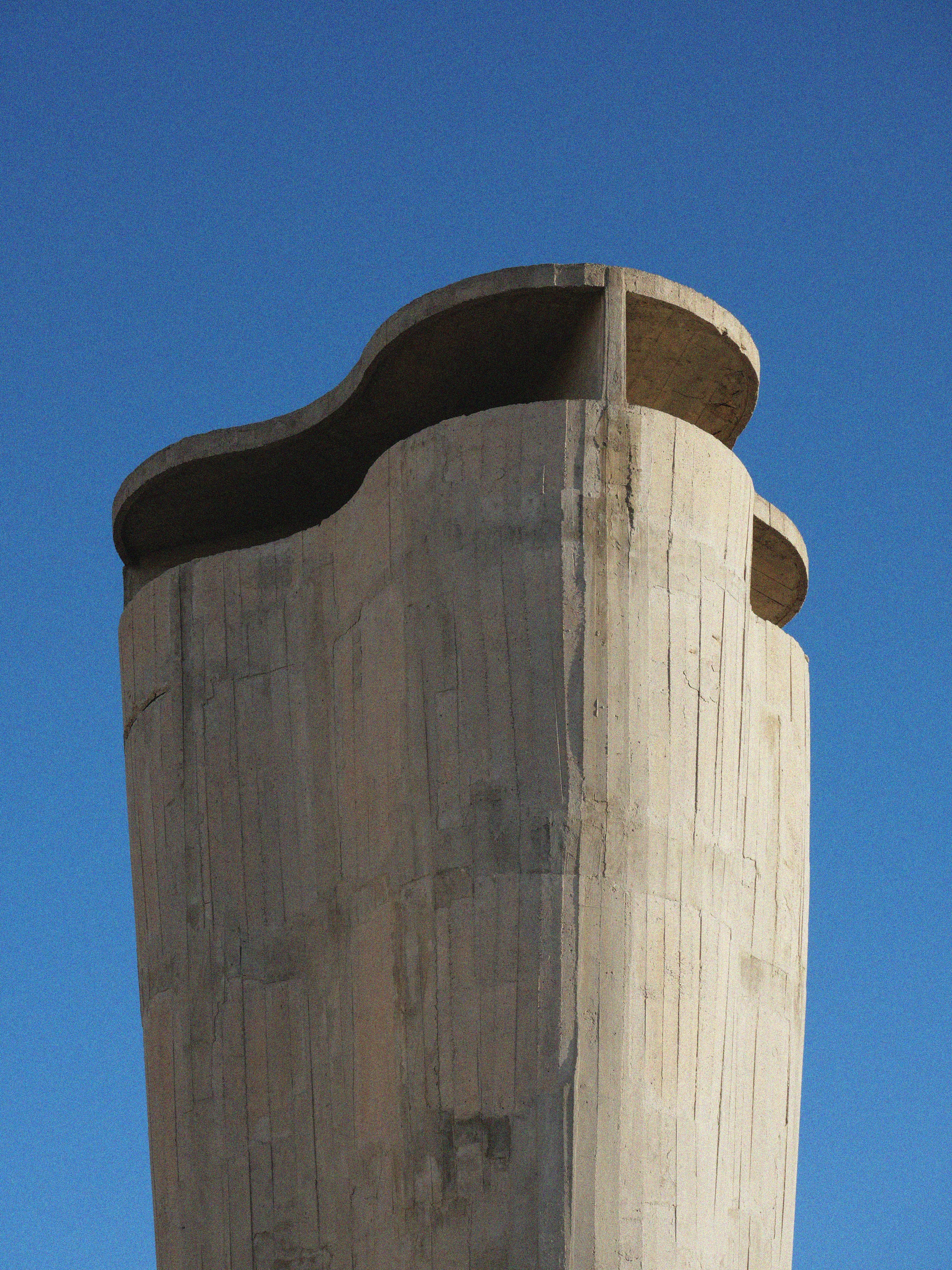 Cobalt Sky, Sculpted Curves: A Concrete Column Reaching Up