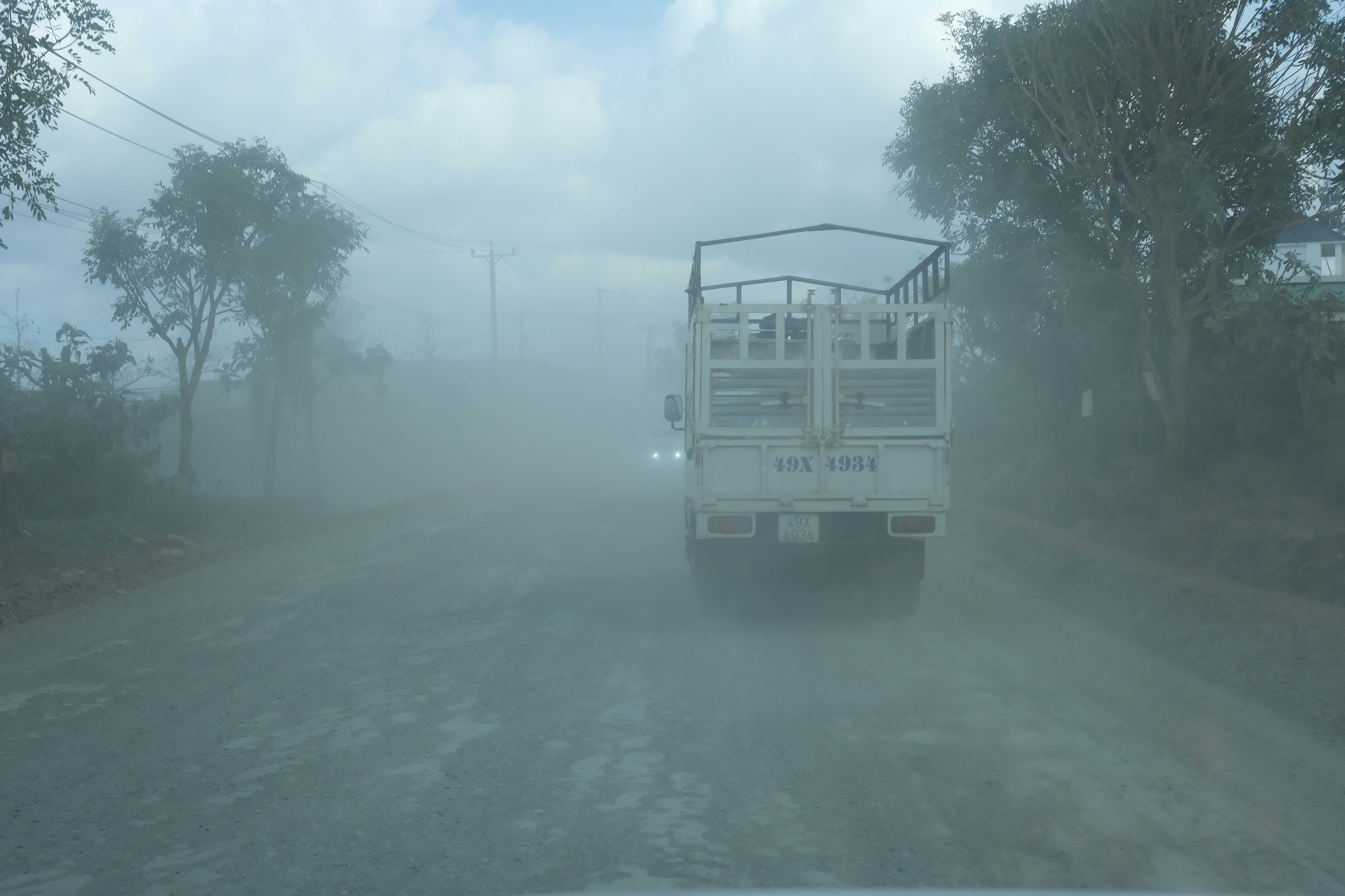 Dust-Cloaked Corridor: A Freight Truck Vanishes Into the Haze